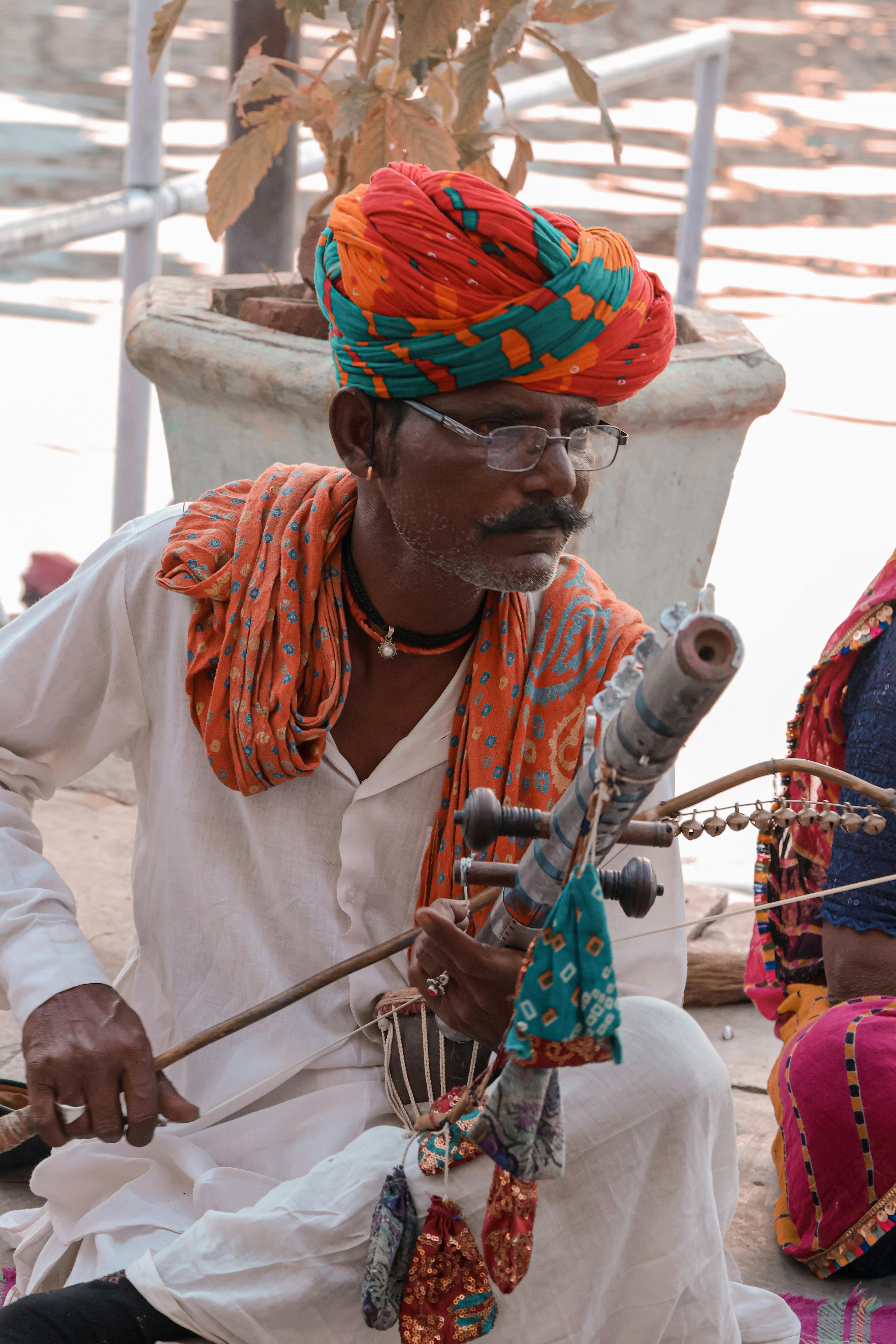 Man in Turban Sitting and Playing Musical Instrument · Free Stock Photo