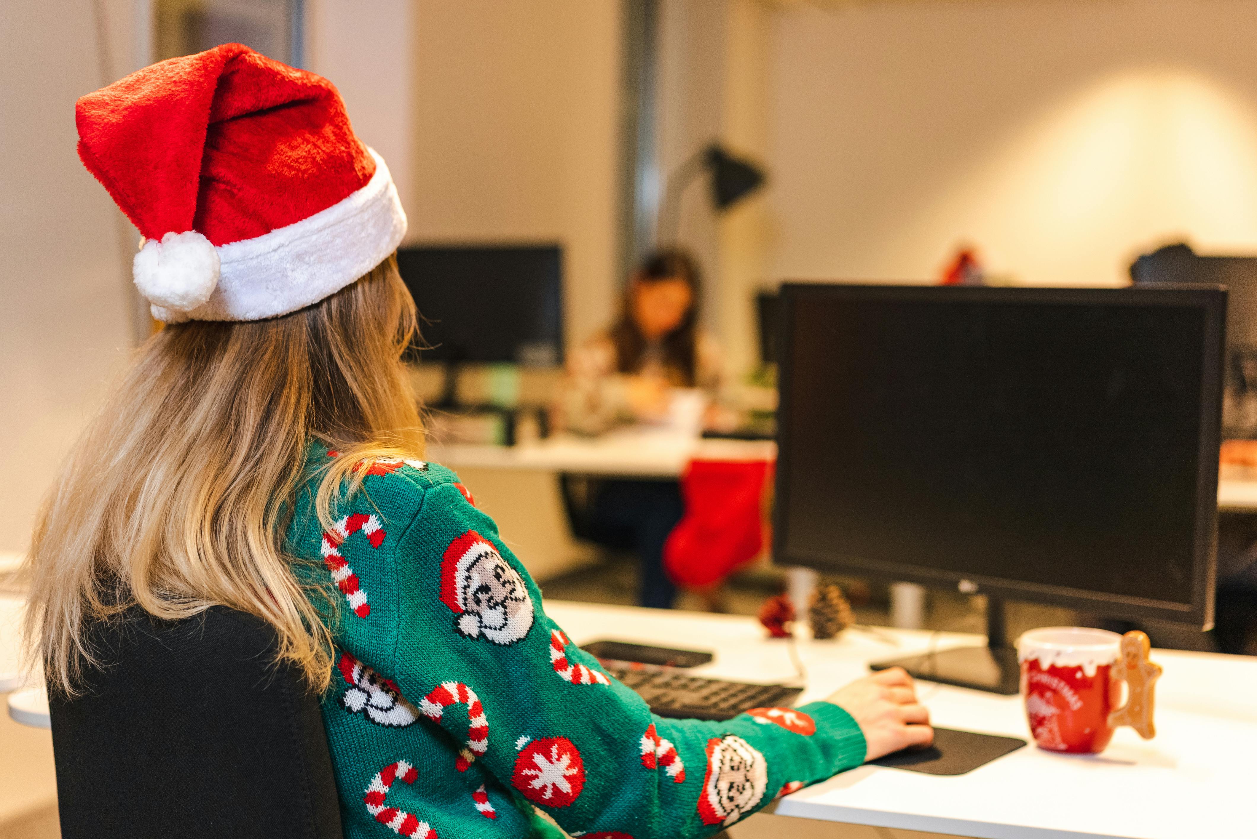 A Woman Wearing Christmas Sweater Sitting in Front of a Computer · Free ...