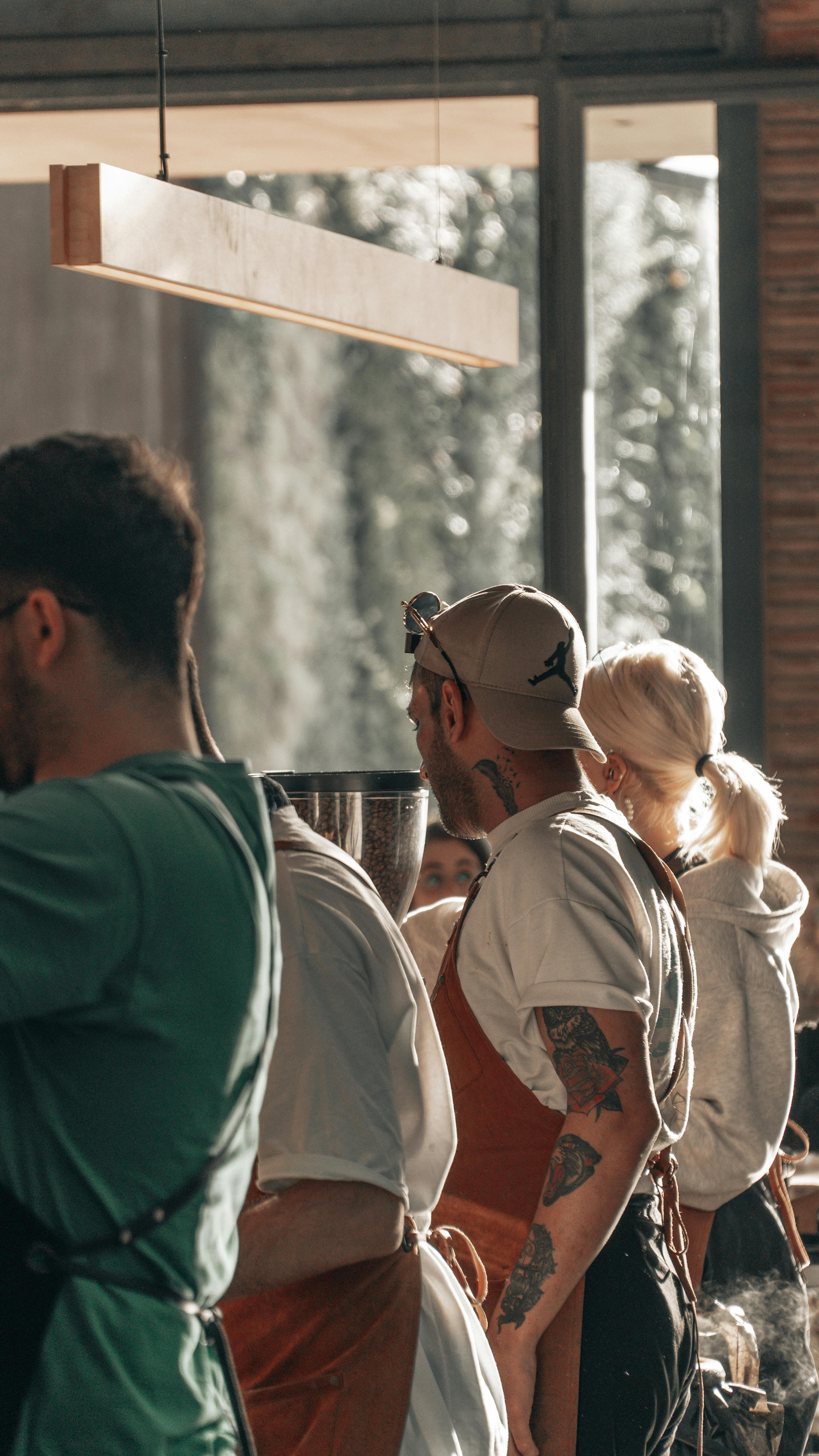 Employees Wearing Aprons Standing on Restaurant Counter · Free Stock Photo