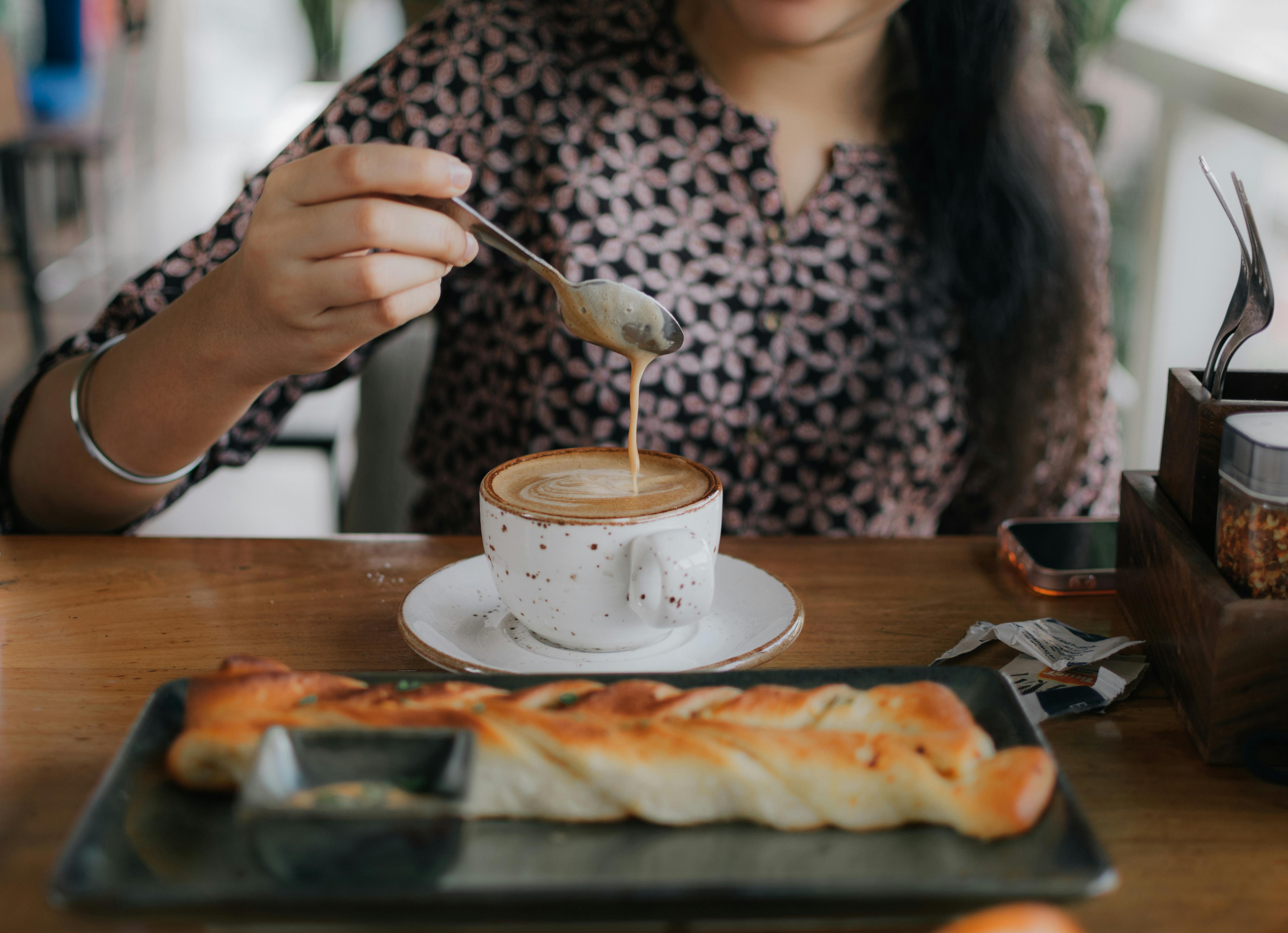 Woman Drinking Coffee at Table in Cafe · Free Stock Photo