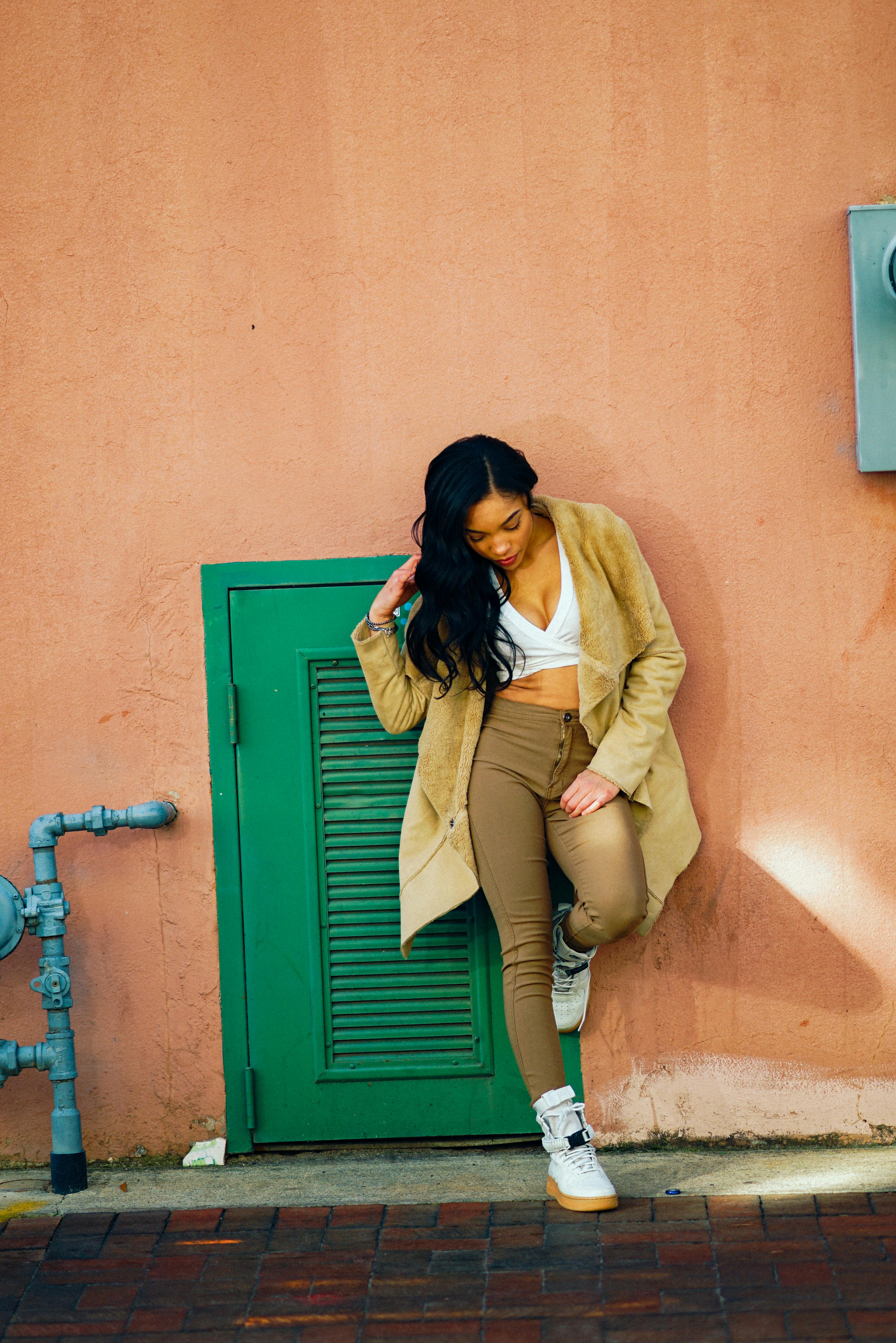 Stylish Woman Leaning on Wall While Looking Down · Free Stock Photo