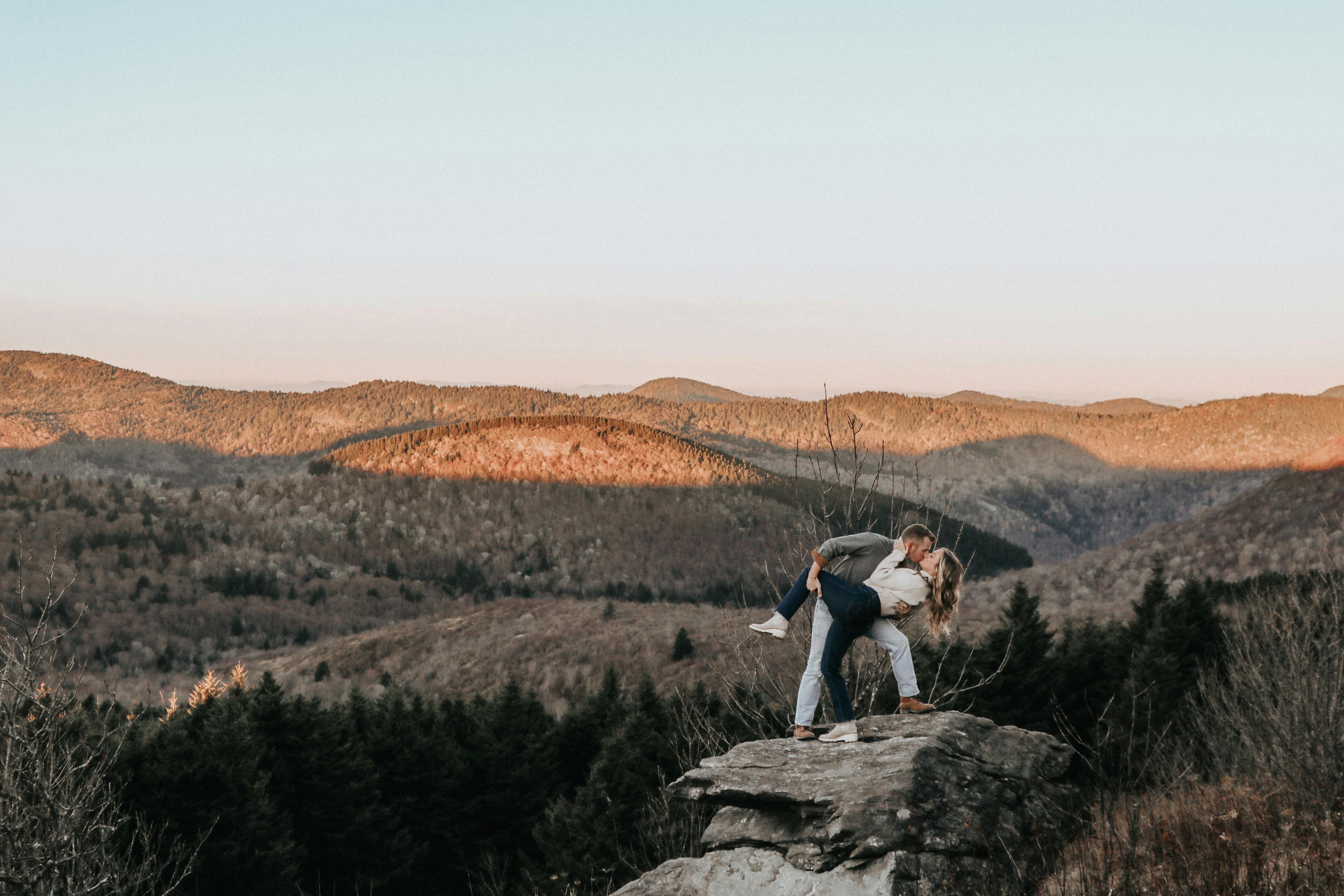 Man Dipping and Kissing his Wife on a Rock Formation · Free Stock Photo
