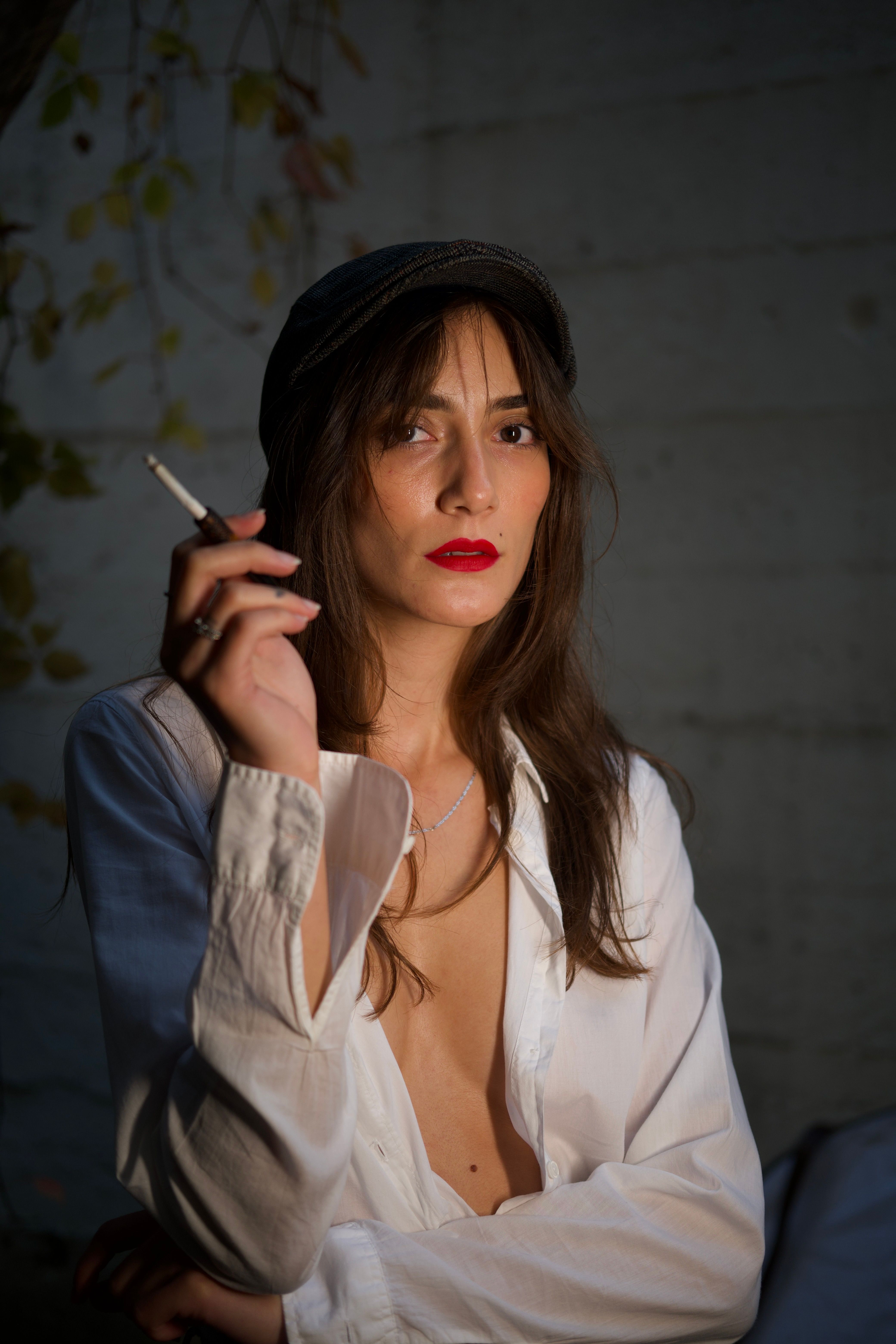 Woman in a Flat Cap and a White Shirt Smoking a Cigarette · Free Stock ...