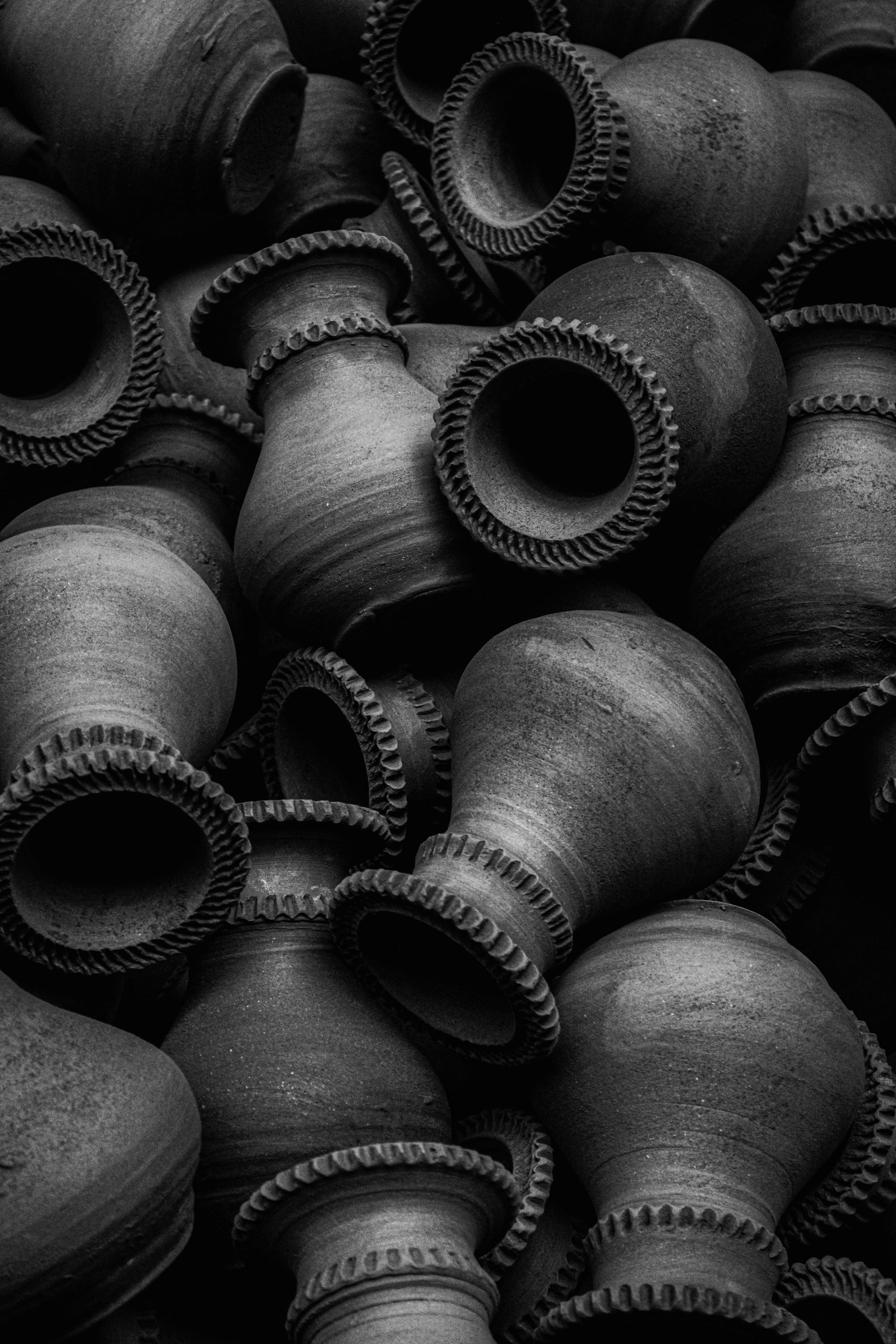 Monochrome Shot of Pile of Clay Jars · Free Stock Photo