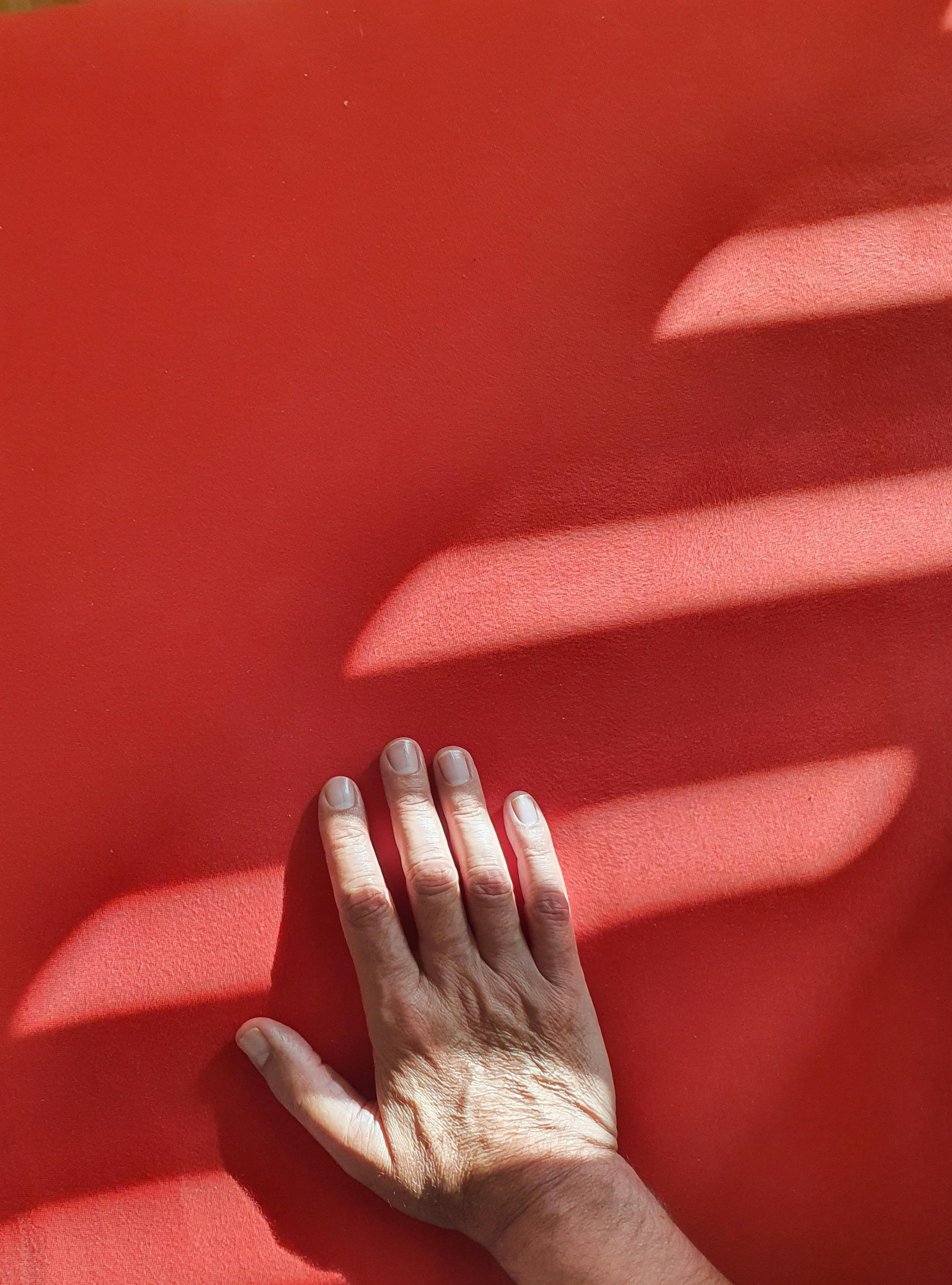 Man Hand in Shadow and Sunlight on Red Background · Free Stock Photo