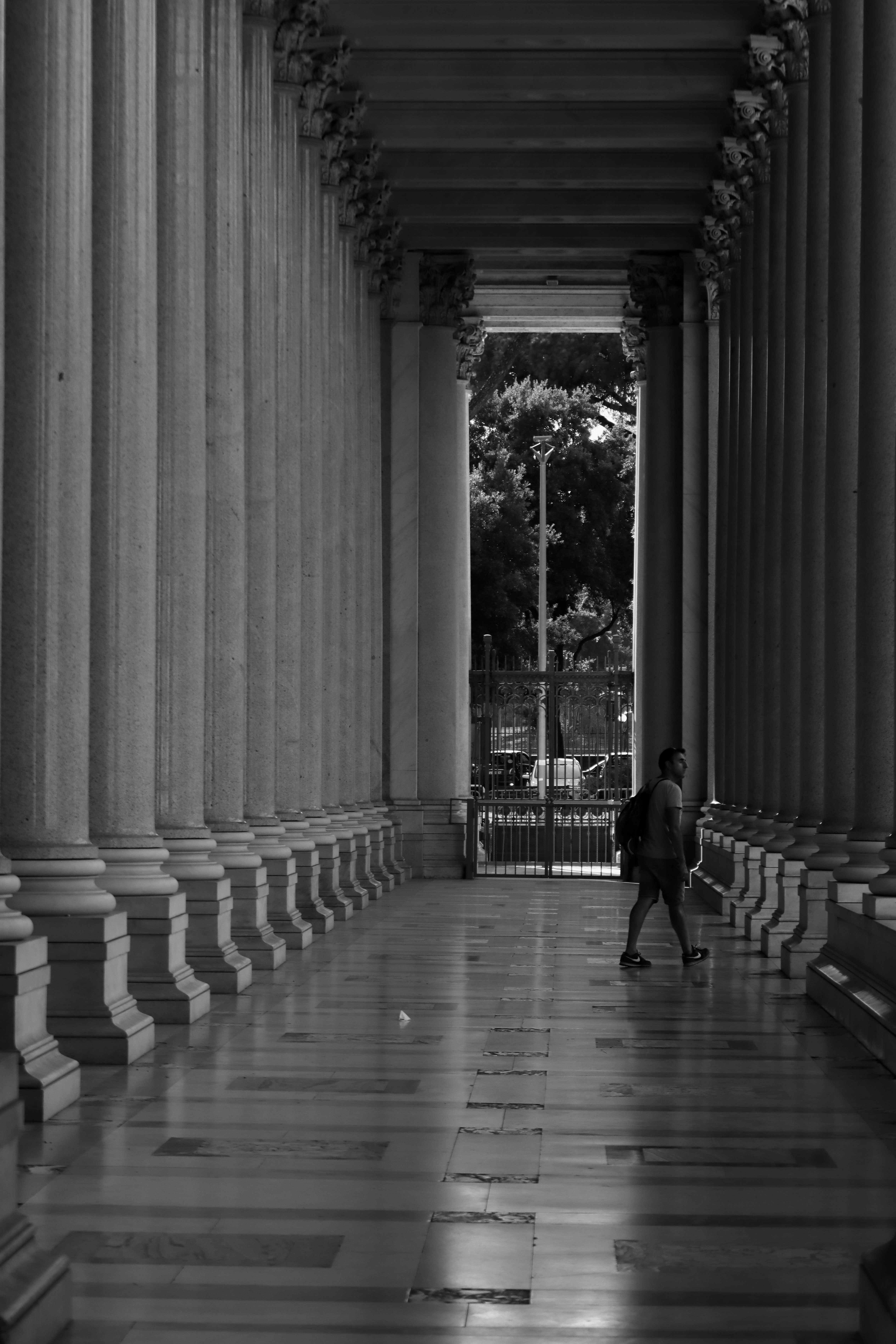 Grayscale Photo of Man Walking on Hallway · Free Stock Photo