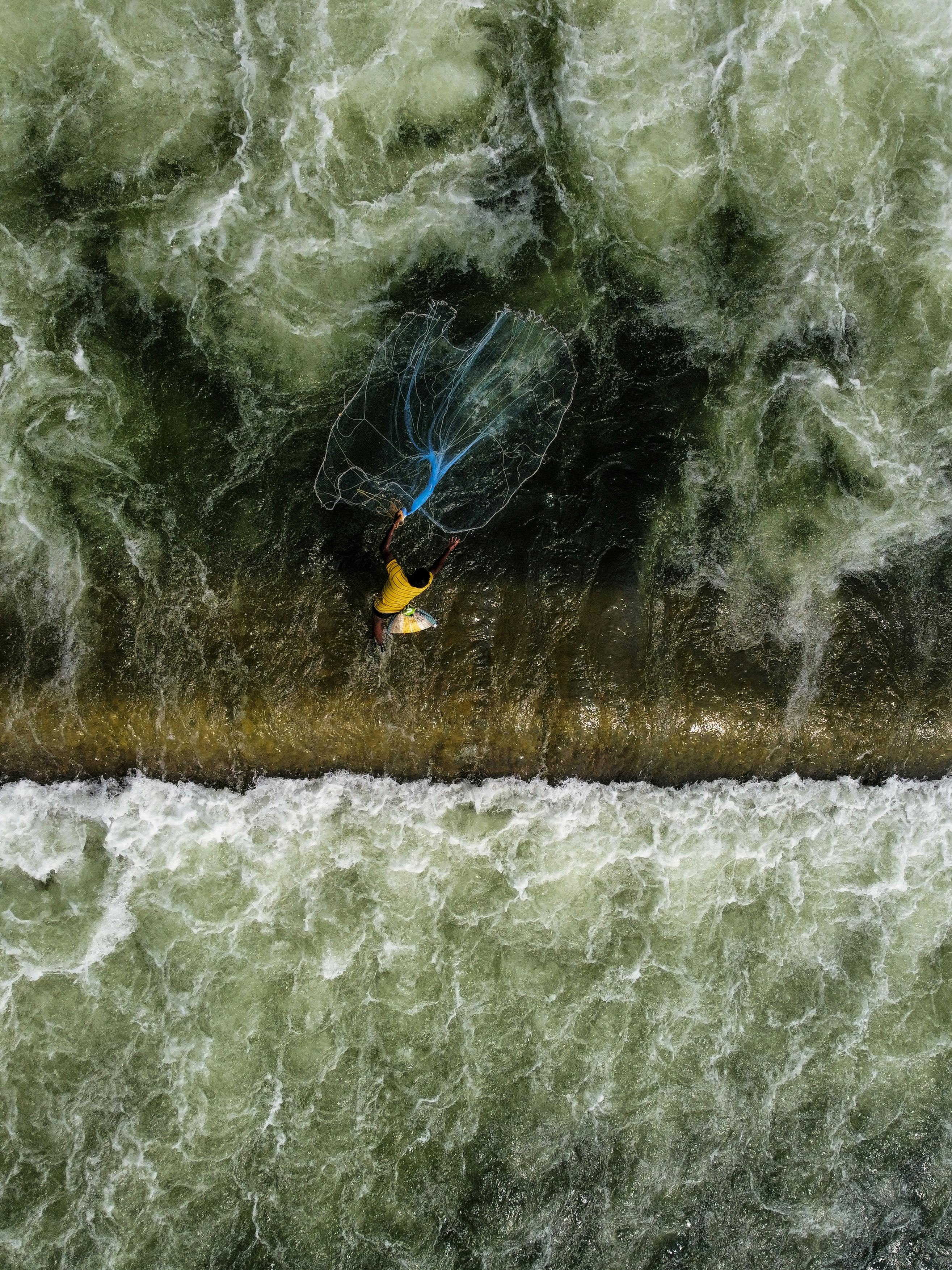 Fisherman with Net in Water · Free Stock Photo