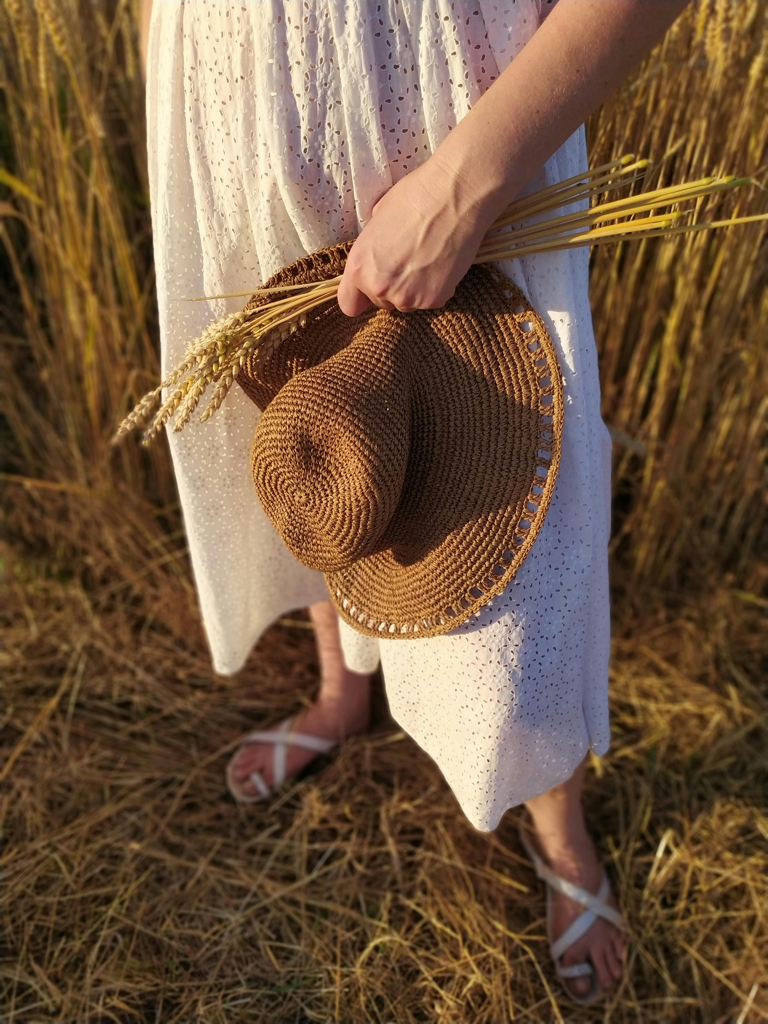 Photo of a Woman with a Hat Carrying a White Goose · Free Stock Photo