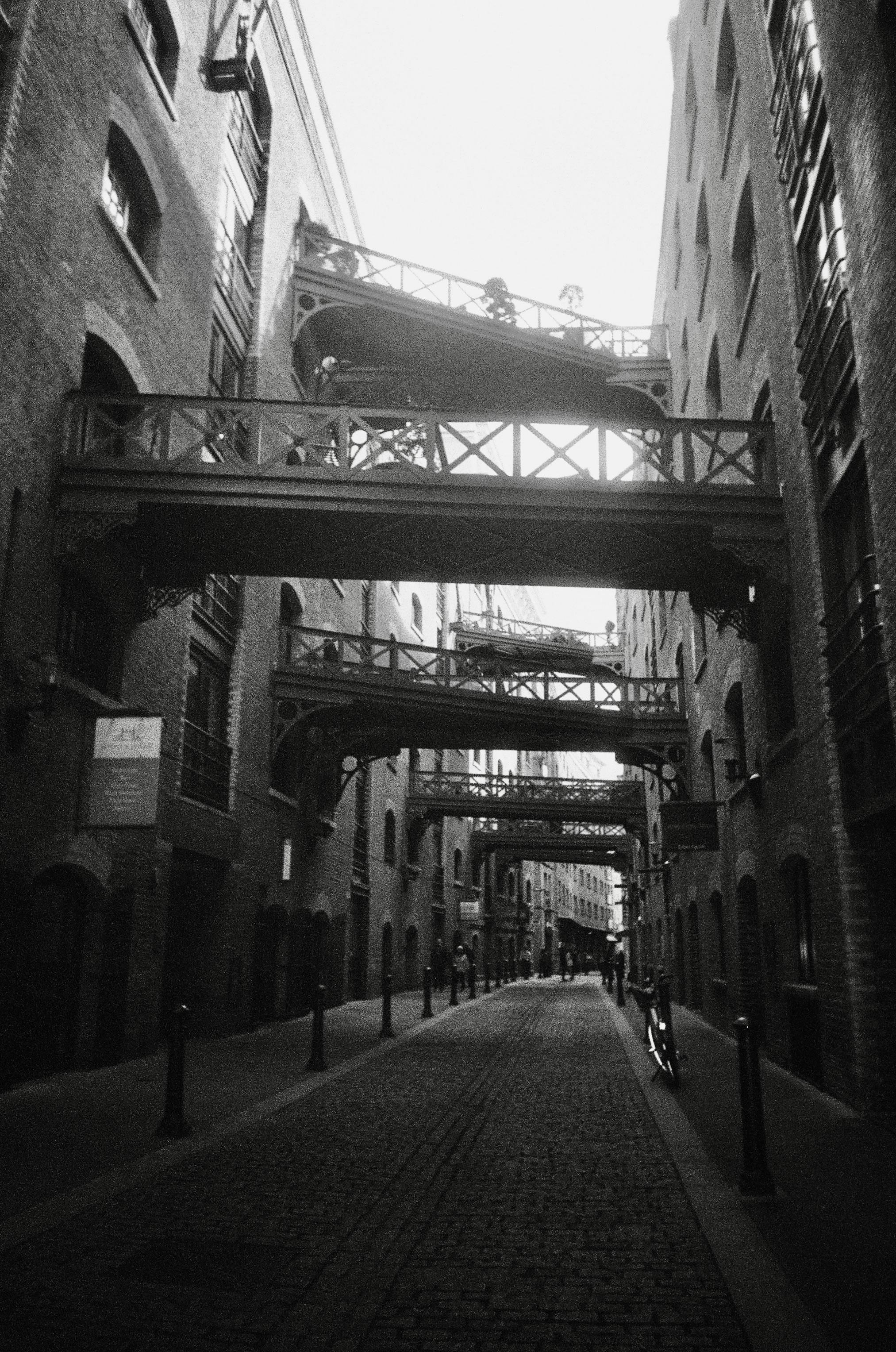 Bridges between Buildings on Cobblestone Street · Free Stock Photo