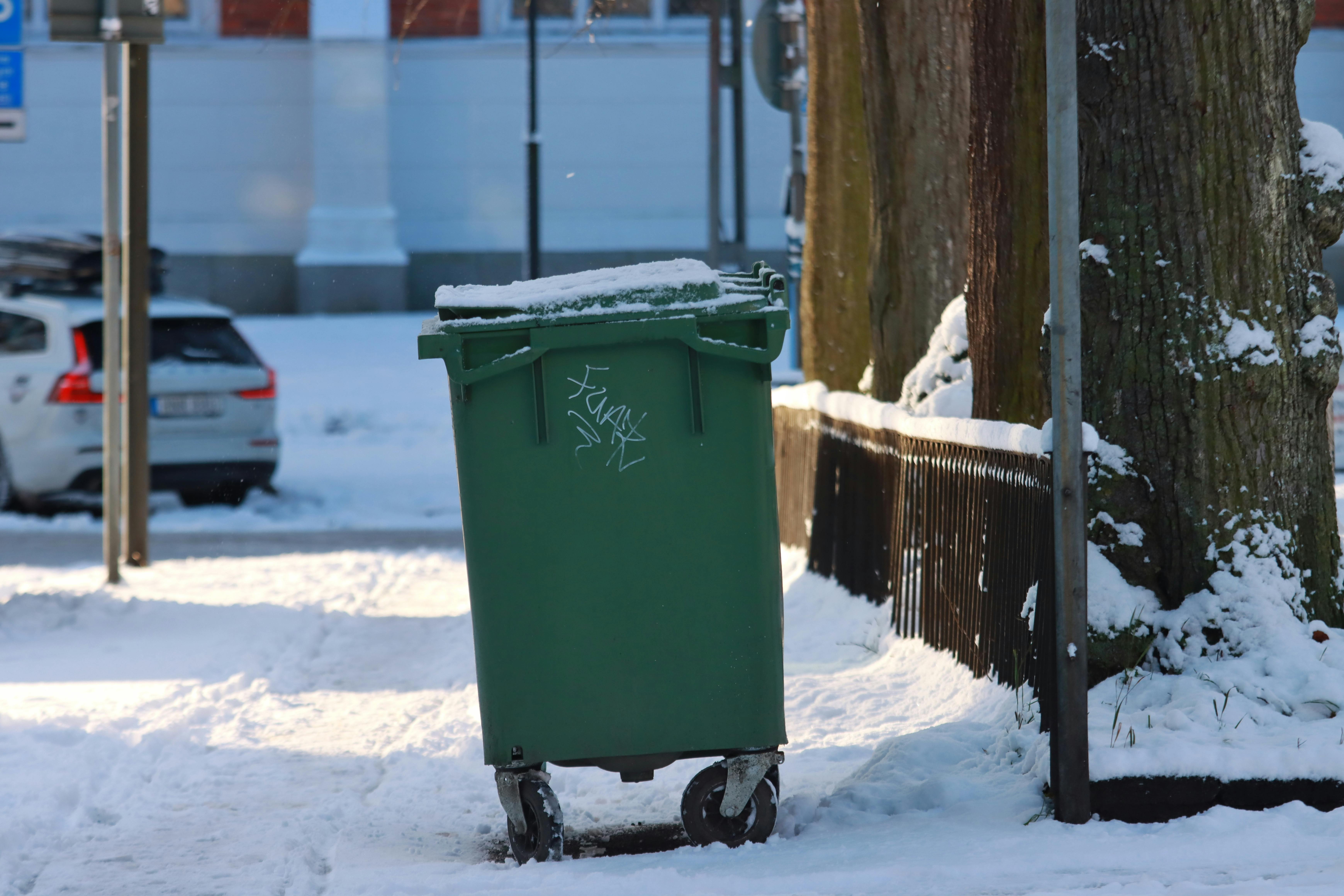 Green Dustbin on a Snowy Street · Free Stock Photo