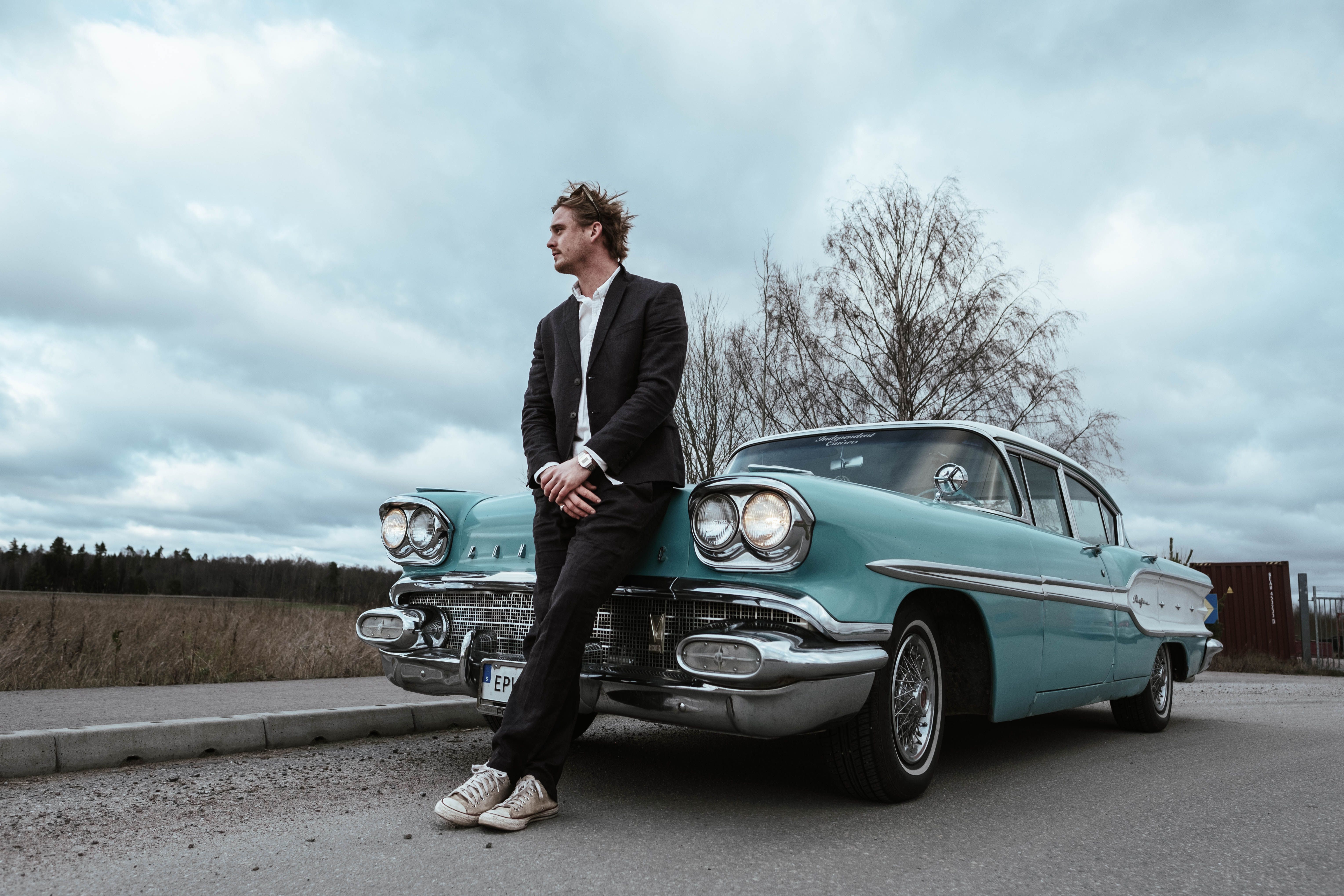 Photo of a Man Leaning on a Vintage Car · Free Stock Photo
