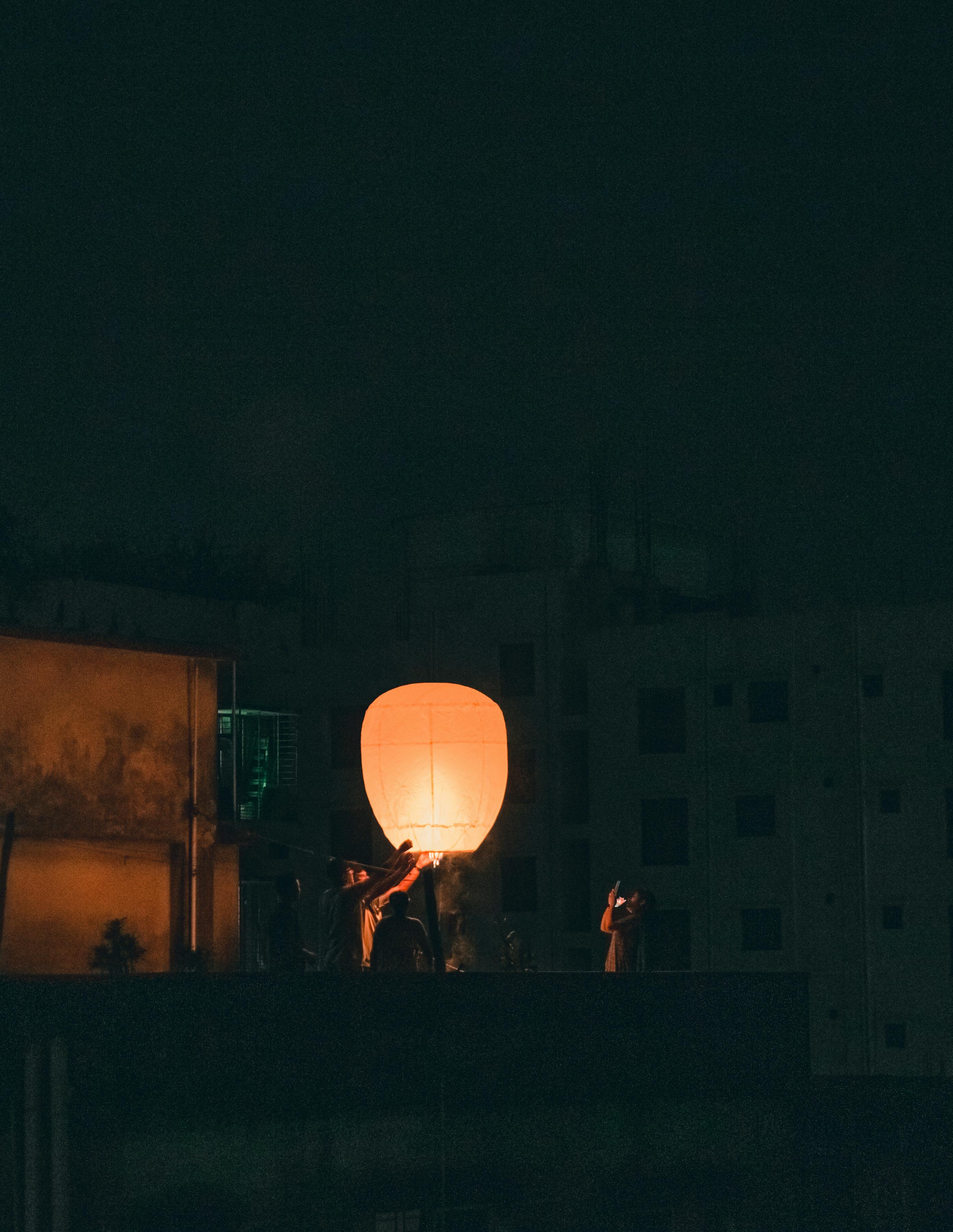People Lighting Up a Chinese Lantern · Free Stock Photo