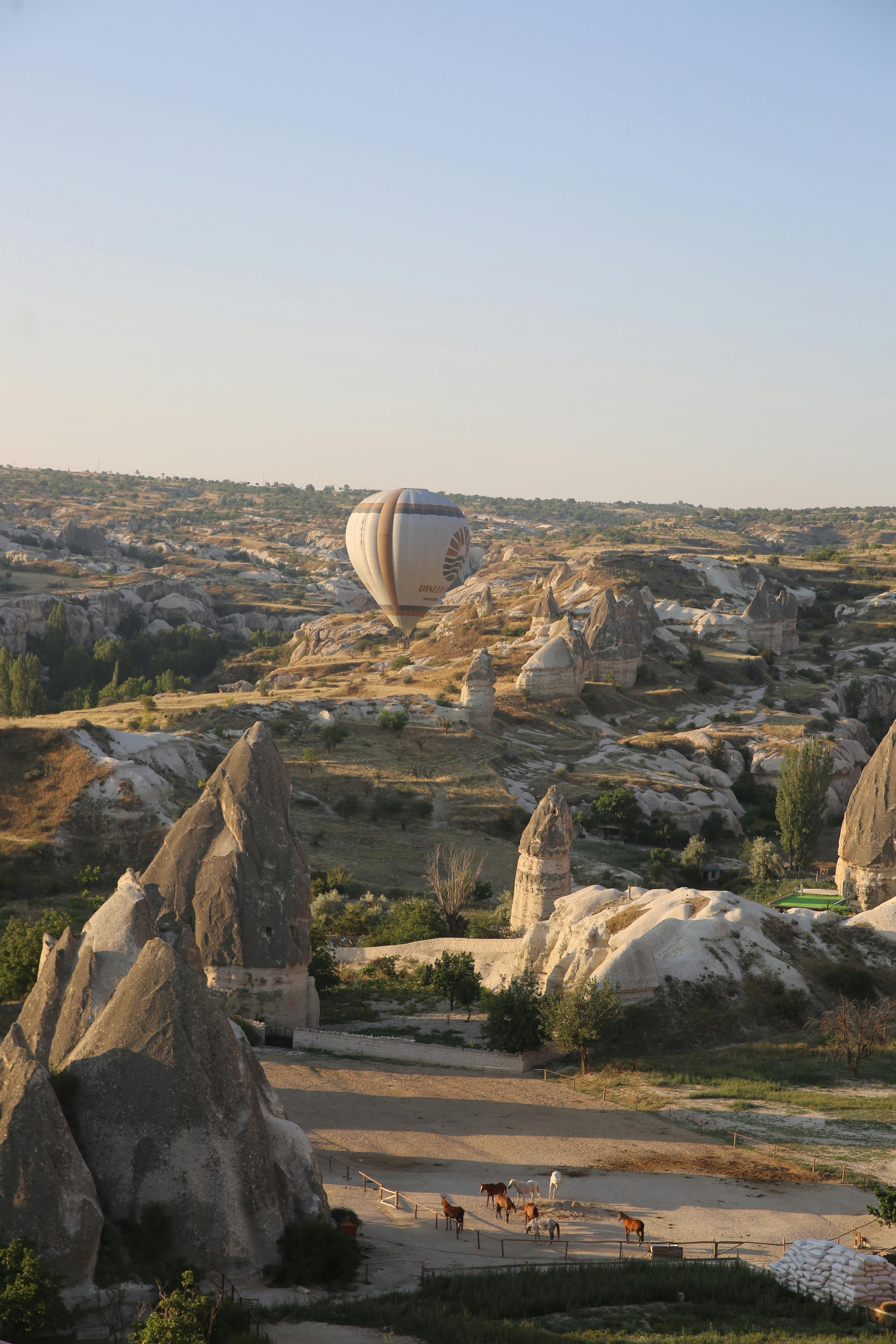 Hot Air Balloon Flying in Rocky Landscape · Free Stock Photo