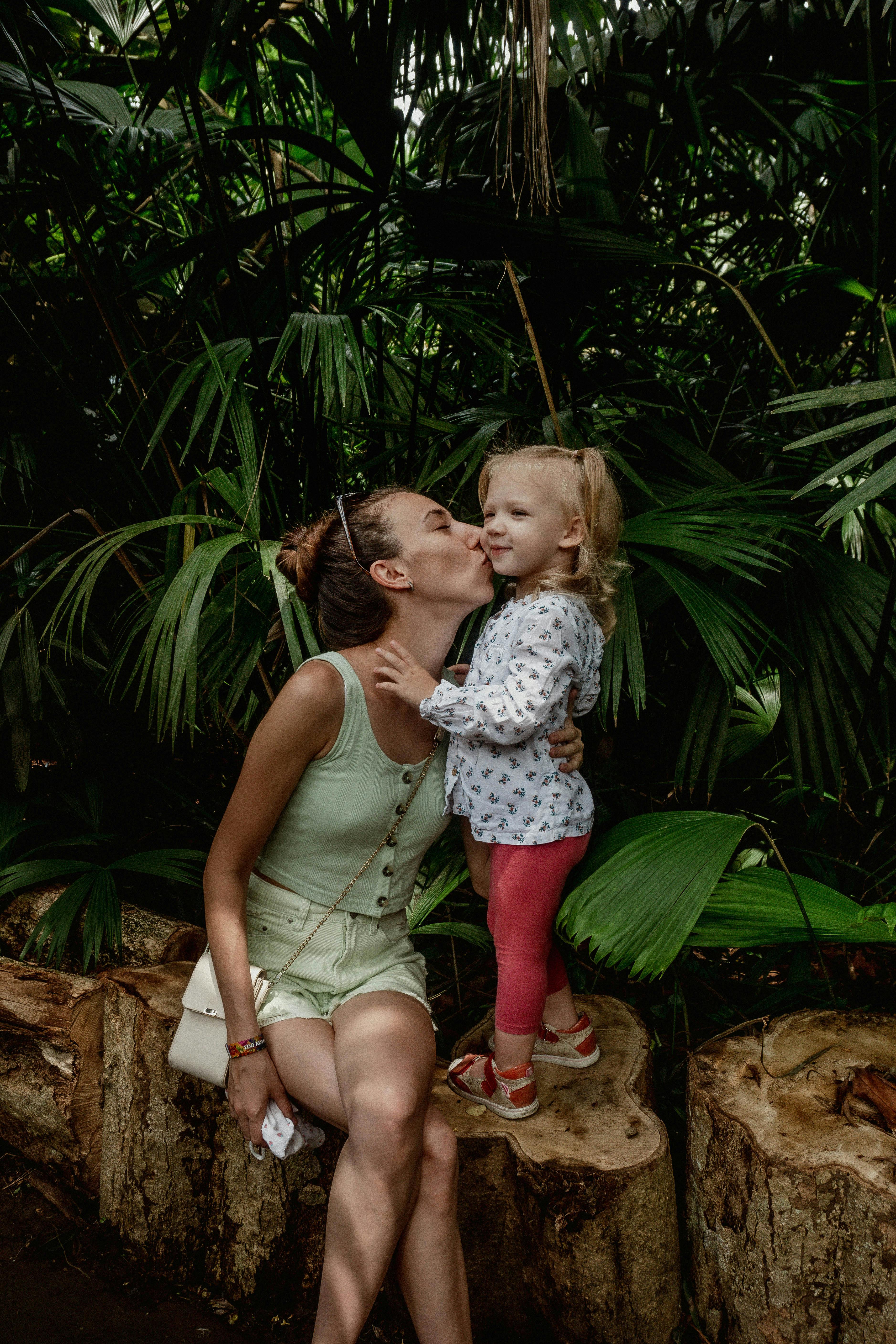 Mother and Daughter on Tree Stumps · Free Stock Photo
