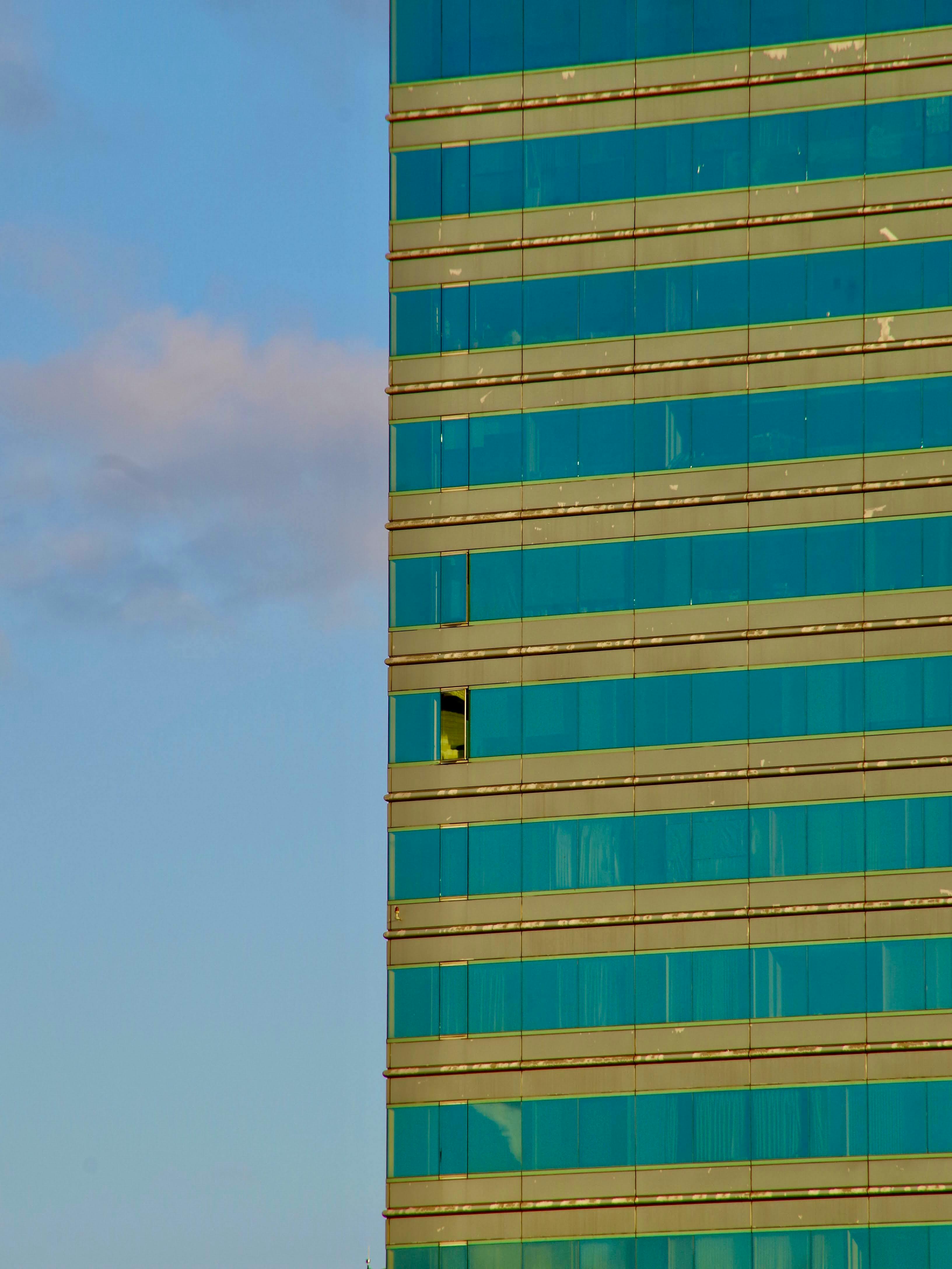Skyscraper Facade with a Single Open Window · Free Stock Photo