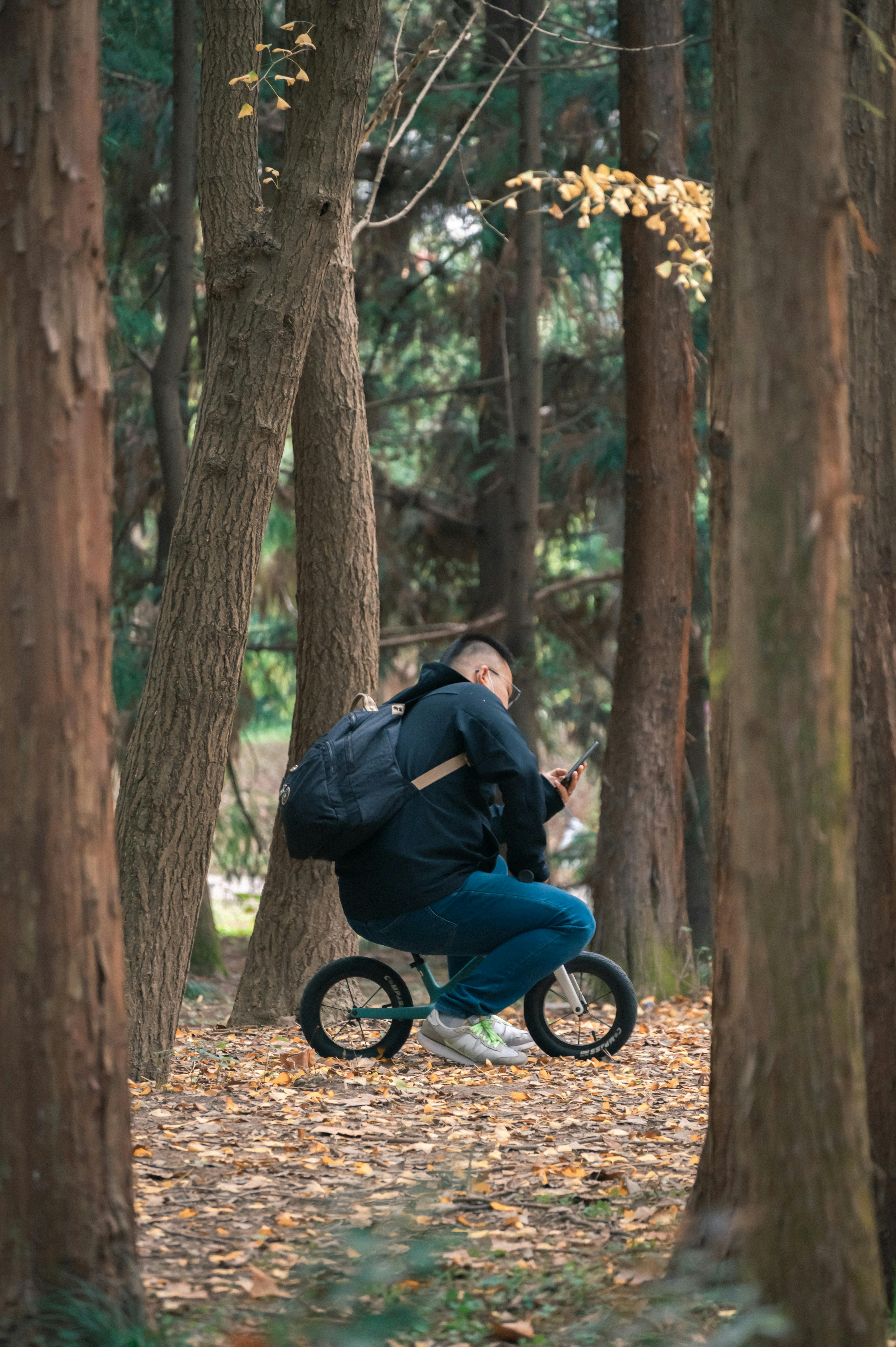 Man Riding a Small Bike near the Trees · Free Stock Photo