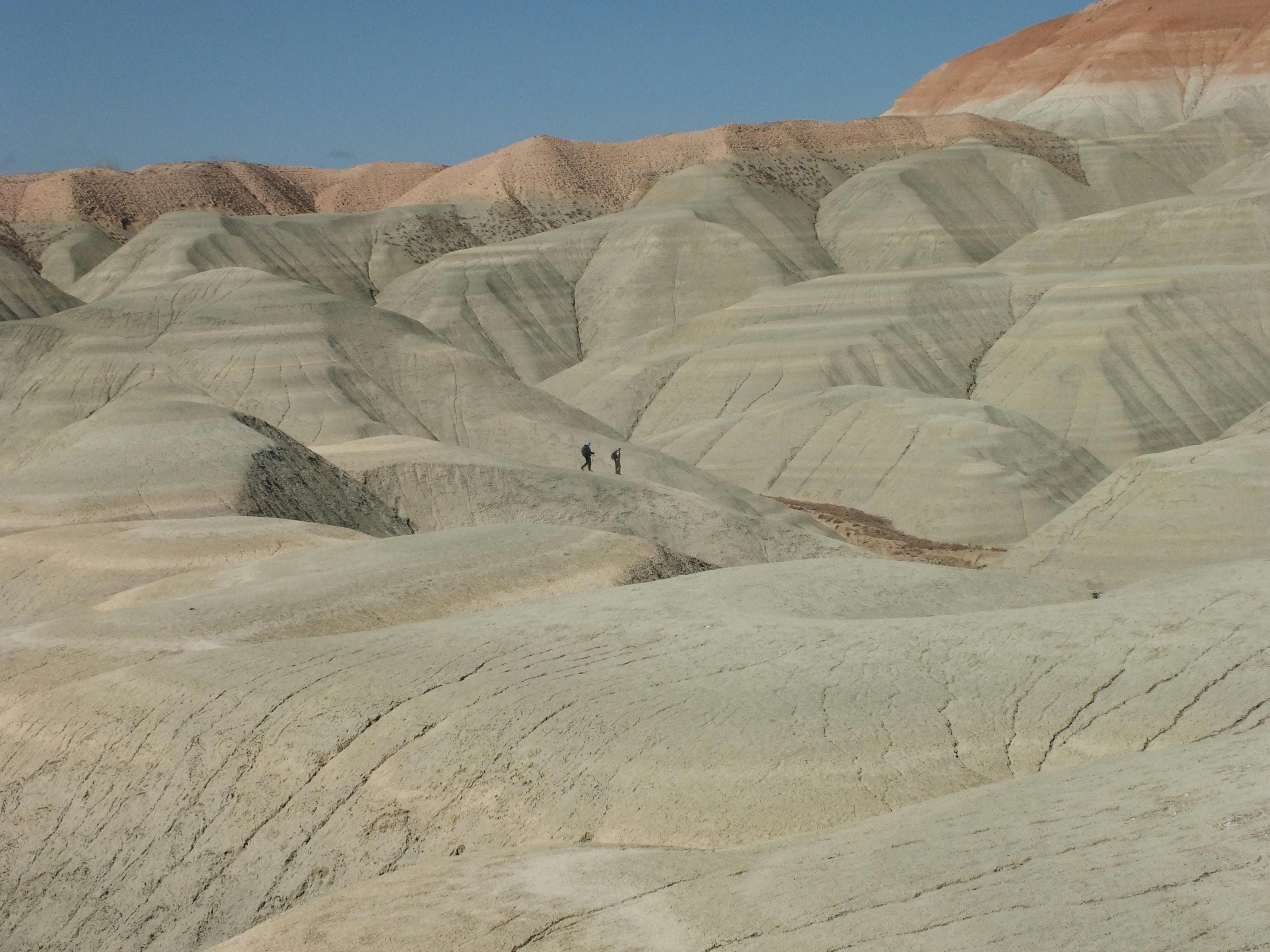 Two People Walking on a Barren Terrain · Free Stock Photo