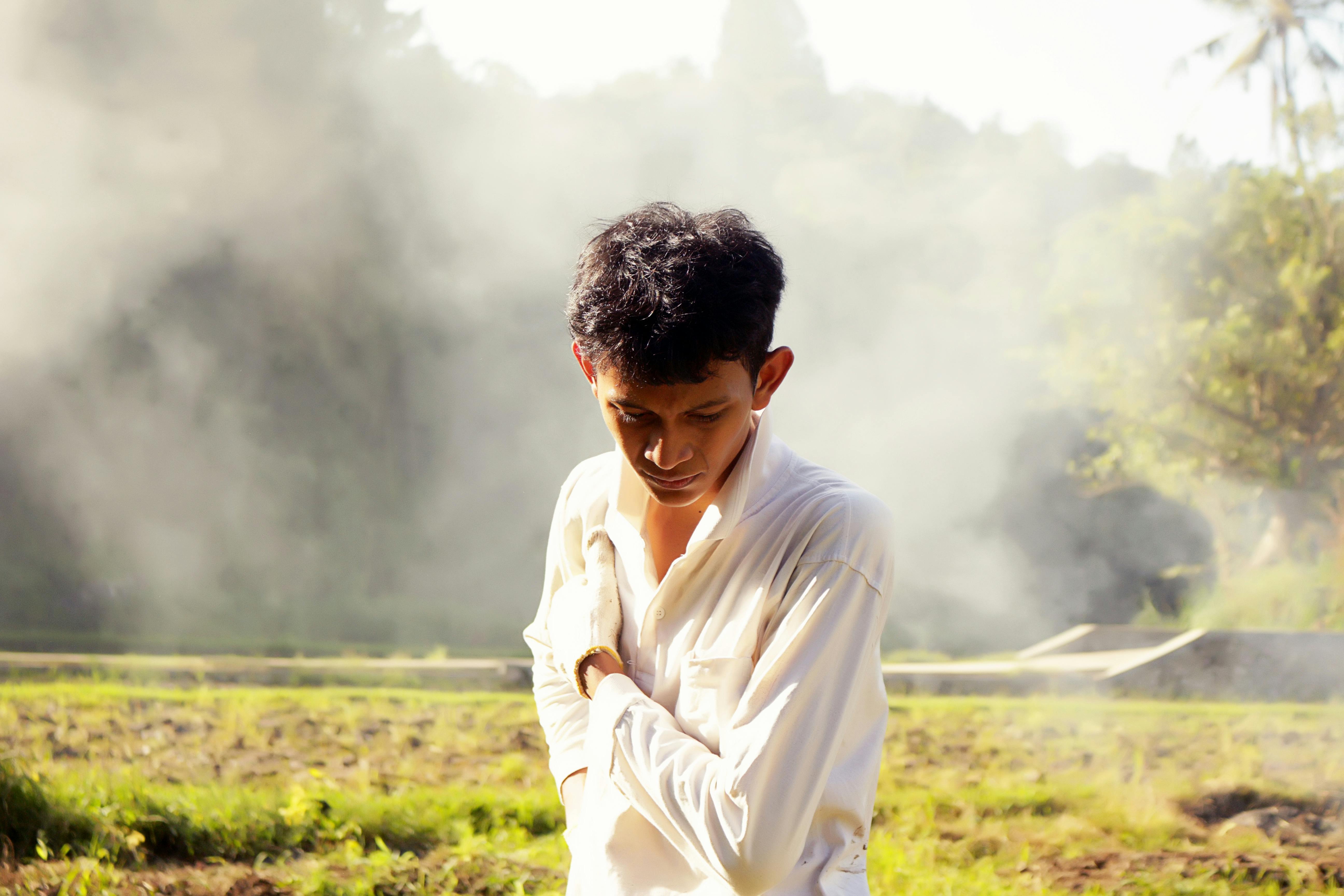 A Man in Maroon Shirt Posing on the Rooftop · Free Stock Photo