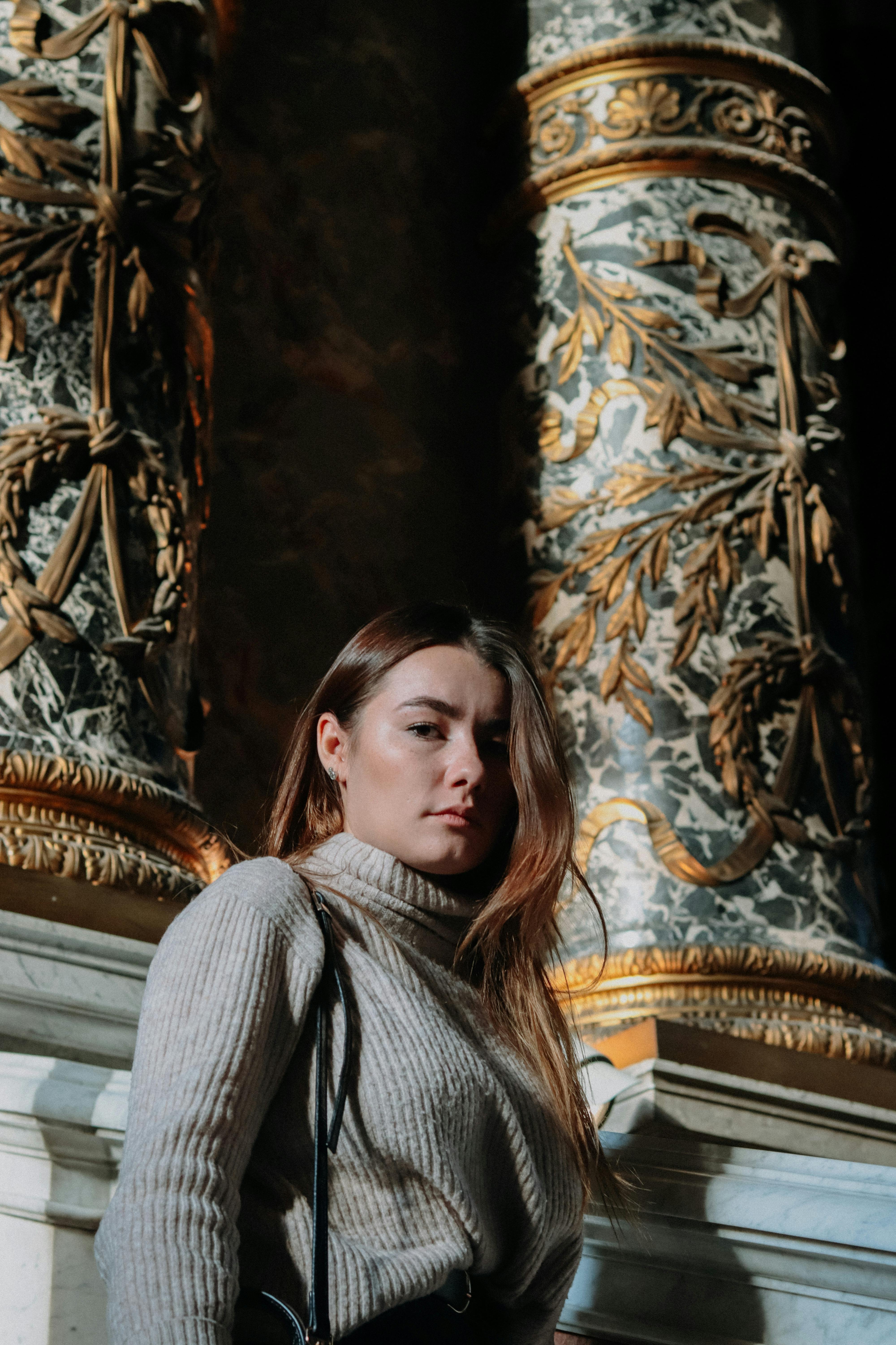 Woman Standing in front of Columns with Carved Details · Free Stock Photo