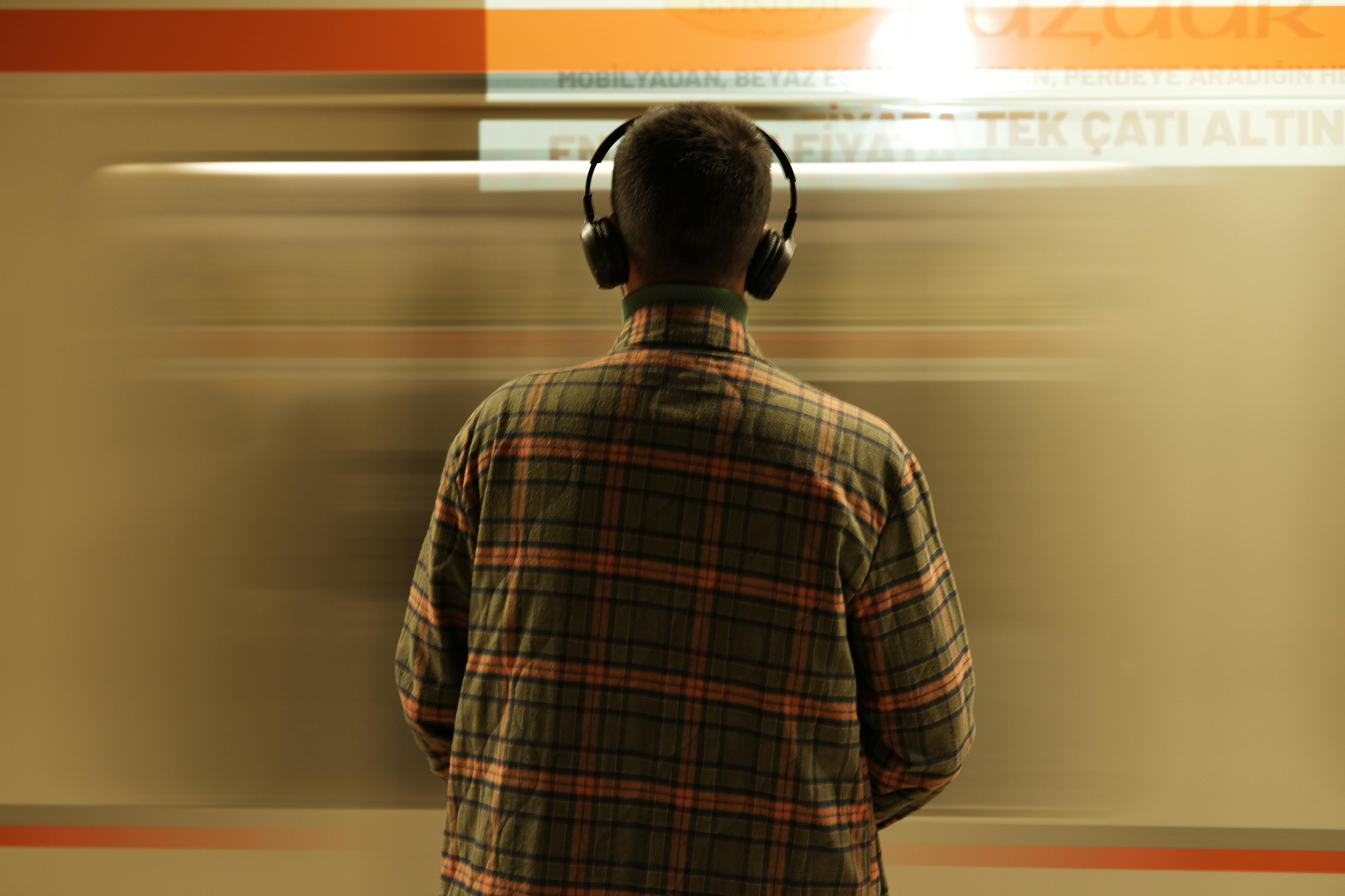 Man Wearing Black Headphones Beside Train Rail · Free Stock Photo