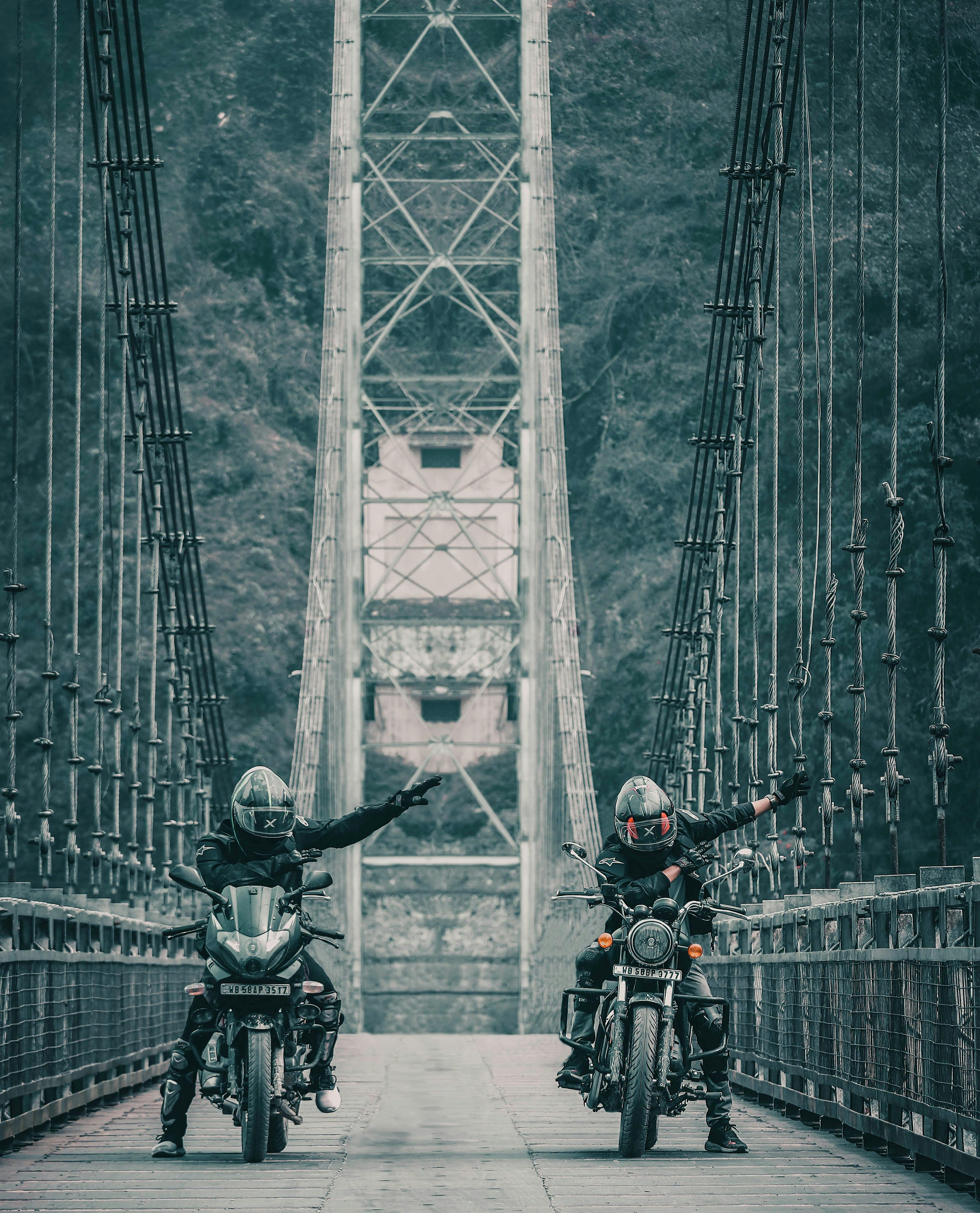 Man Standing on Tip Toes with his Arms Raised next to a Motorcycle ...