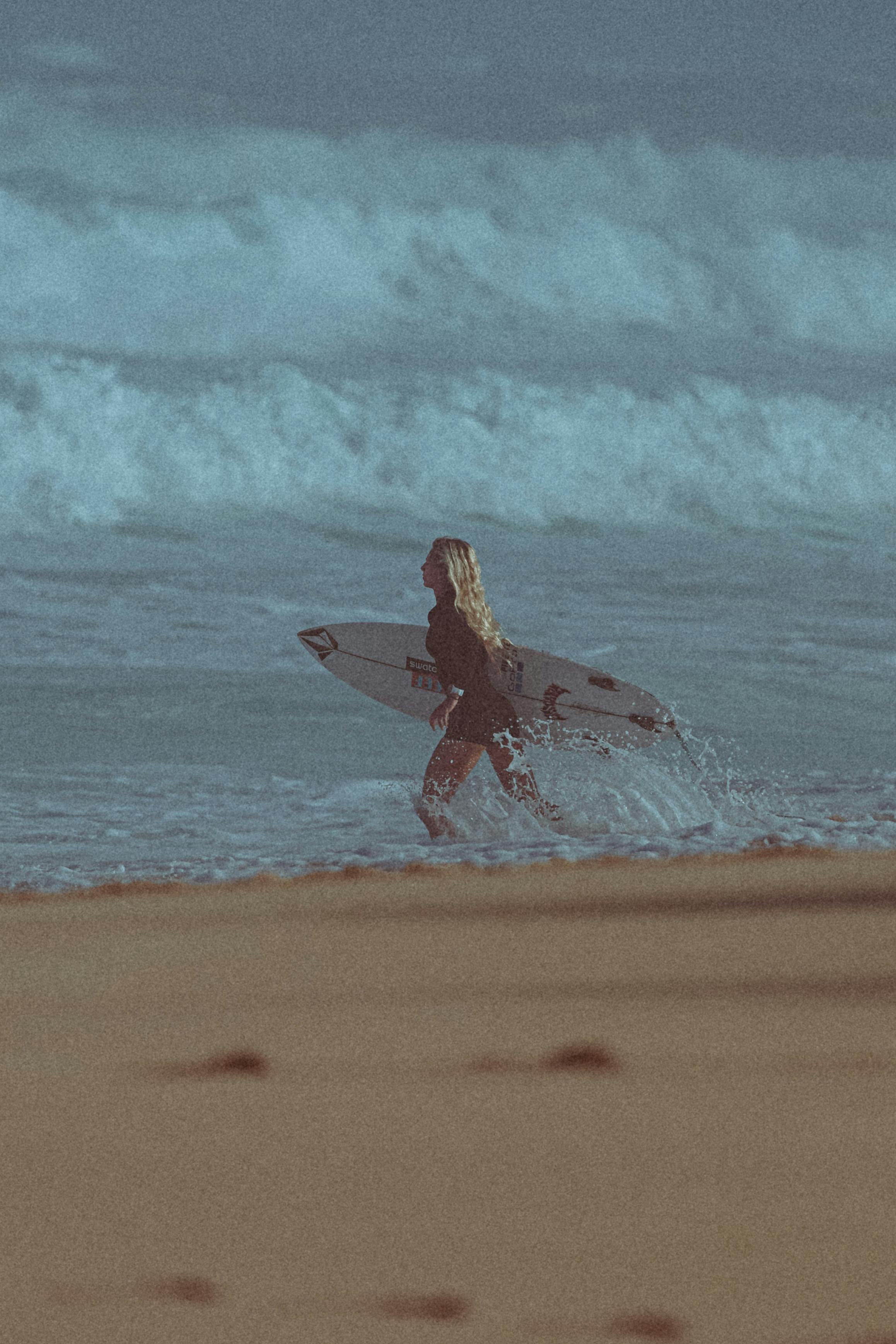 Photograph of a Woman Running while Carrying a Surfboard · Free Stock Photo