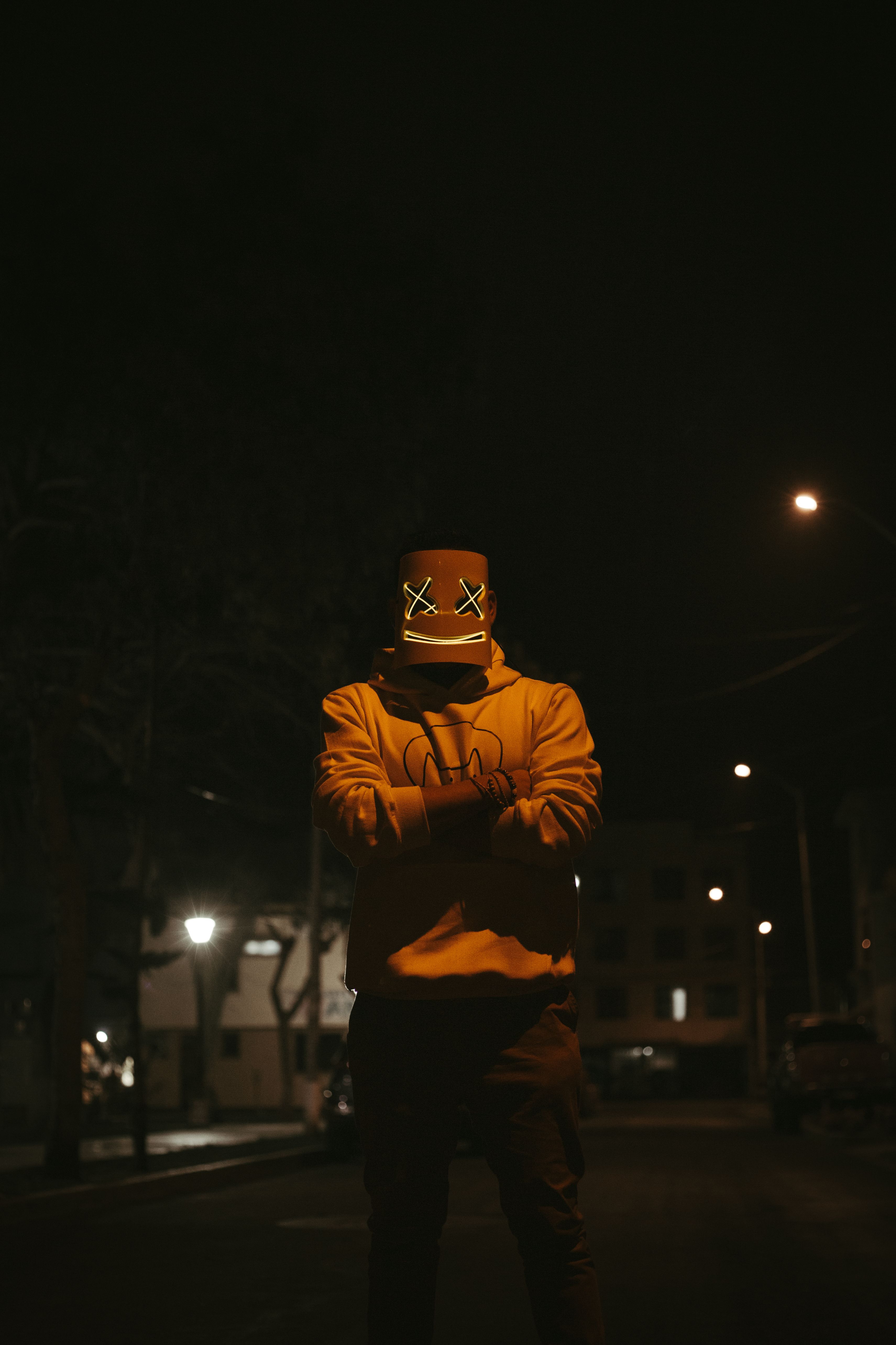 A Man in Wearing a Cap and a Yellow Hoodie at Night · Free Stock Photo