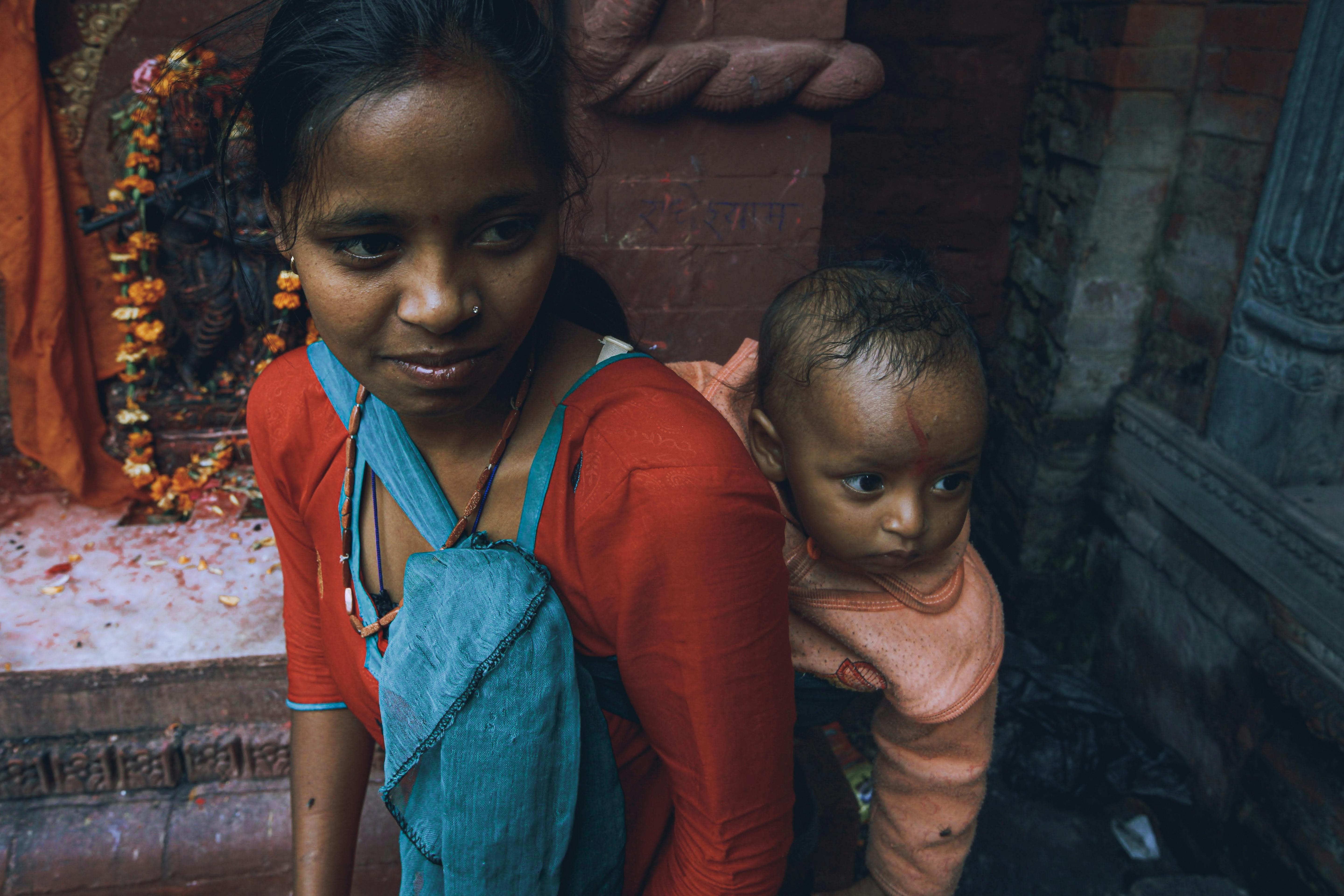 A Woman Carrying a Baby on Her Back · Free Stock Photo
