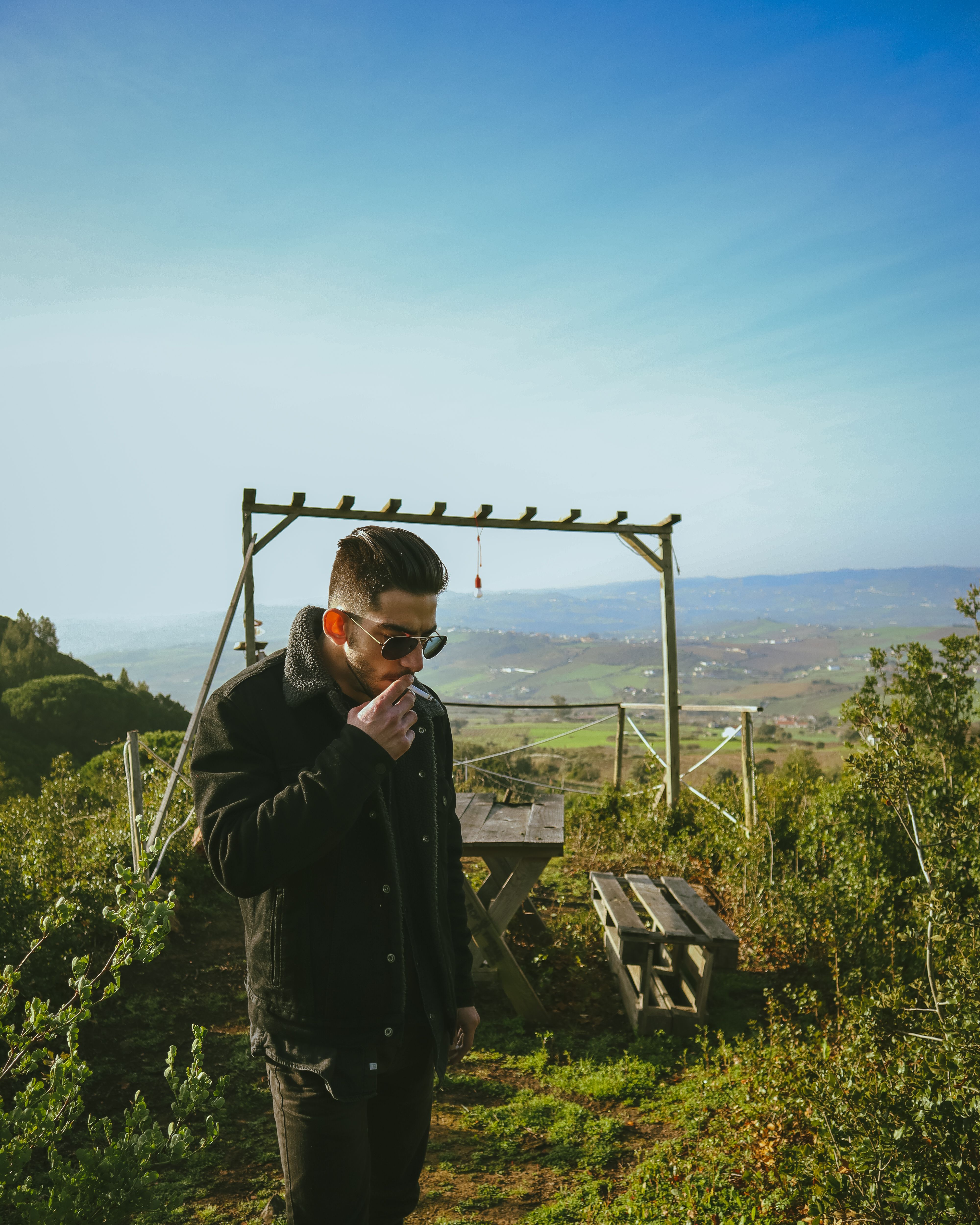 Man Standing Outdoors and Smoking Cigarette · Free Stock Photo