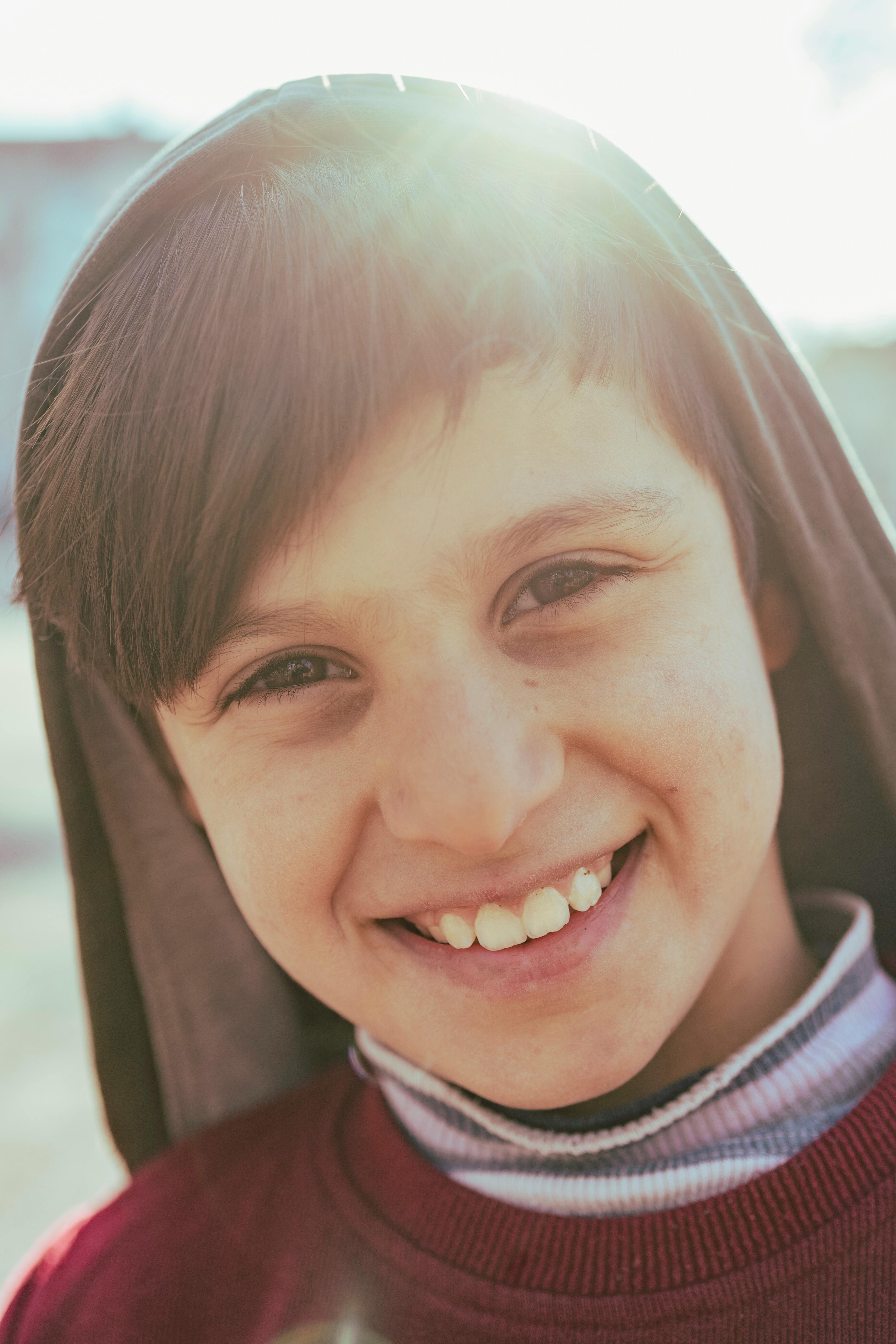 Photo of a Boy Posing next to a Tree Trunk · Free Stock Photo
