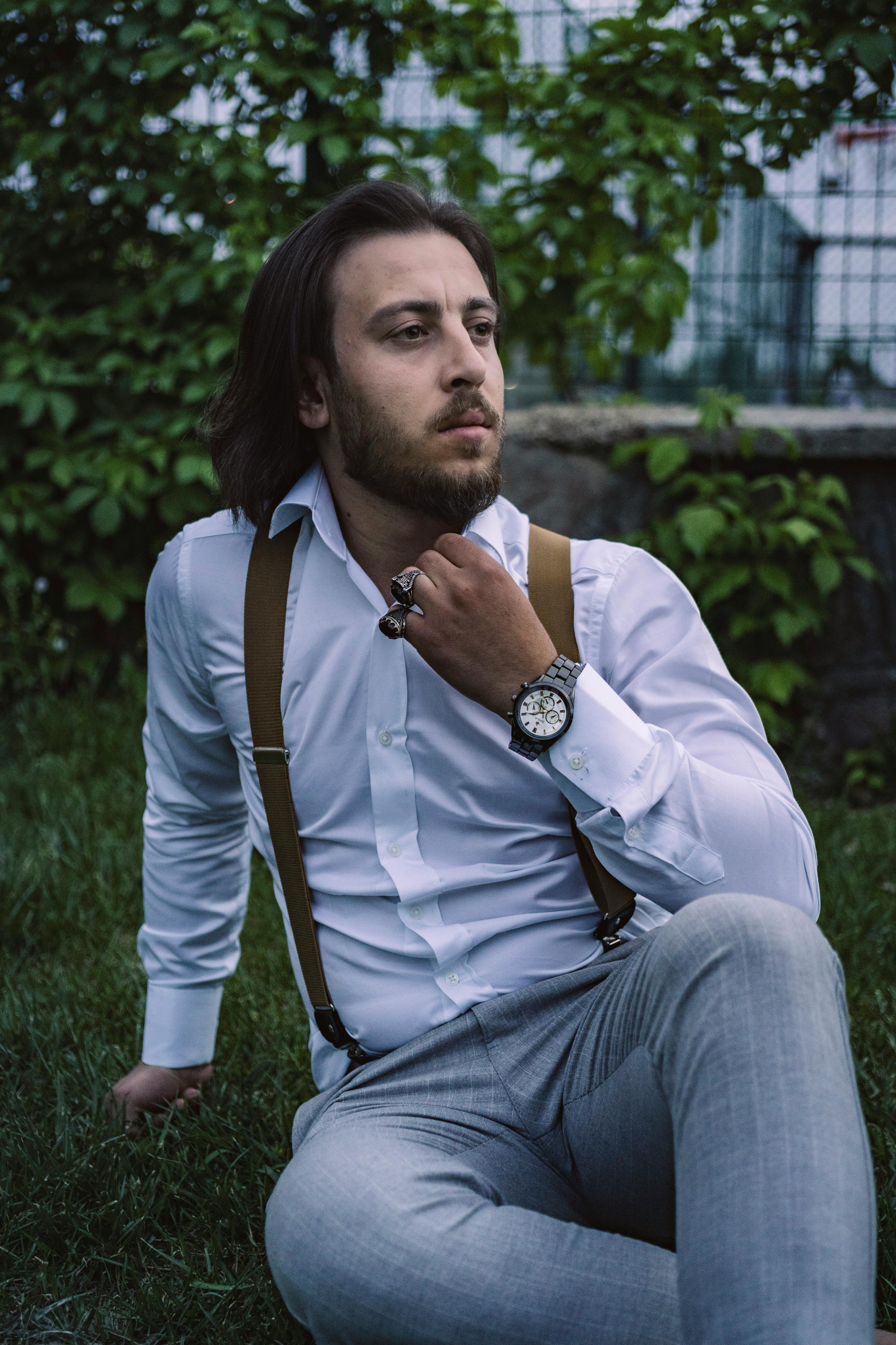 A Man Looking Afar While Sitting on Green Grass · Free Stock Photo