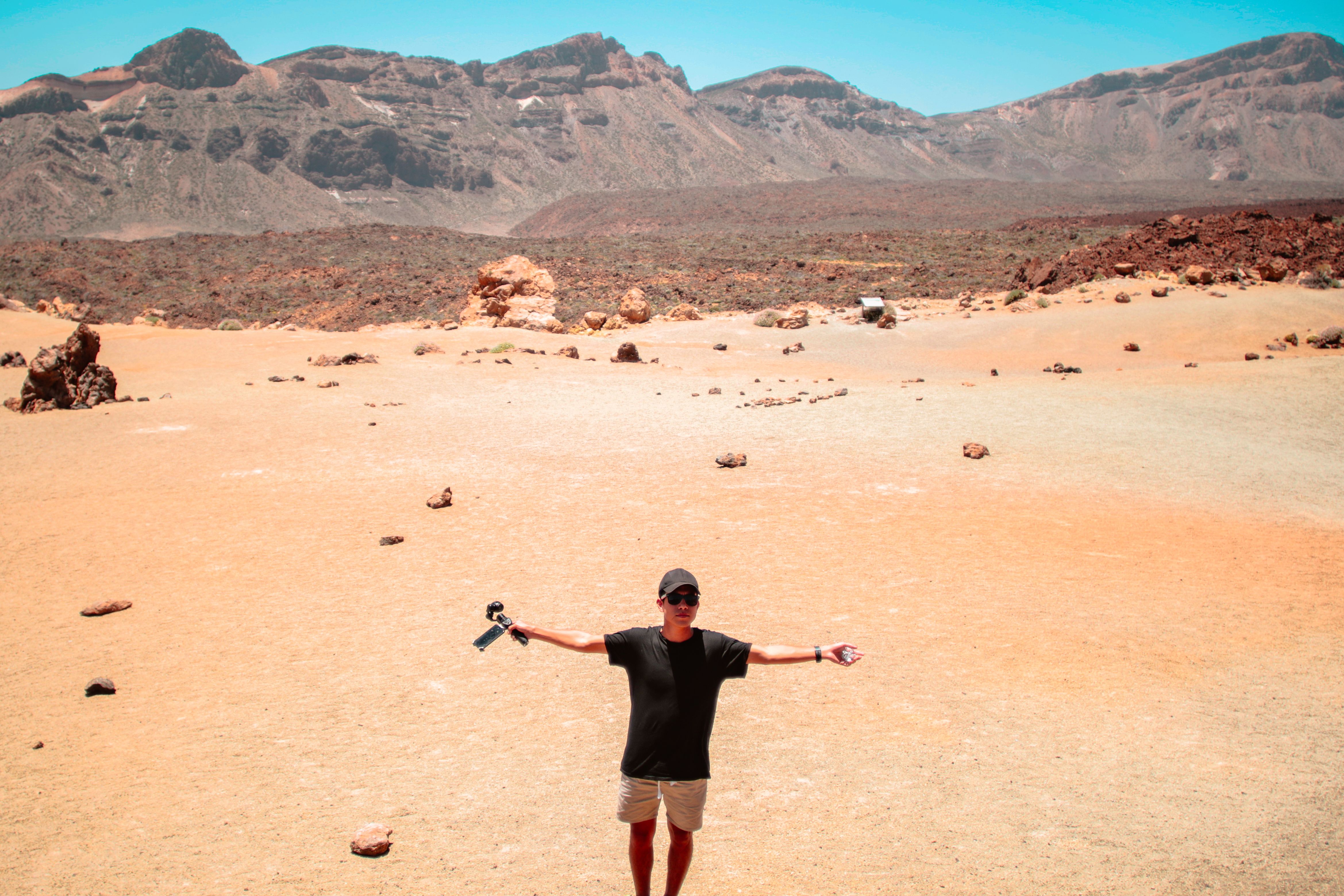 Man Standing in the Desert with Outstretched Arms · Free Stock Photo