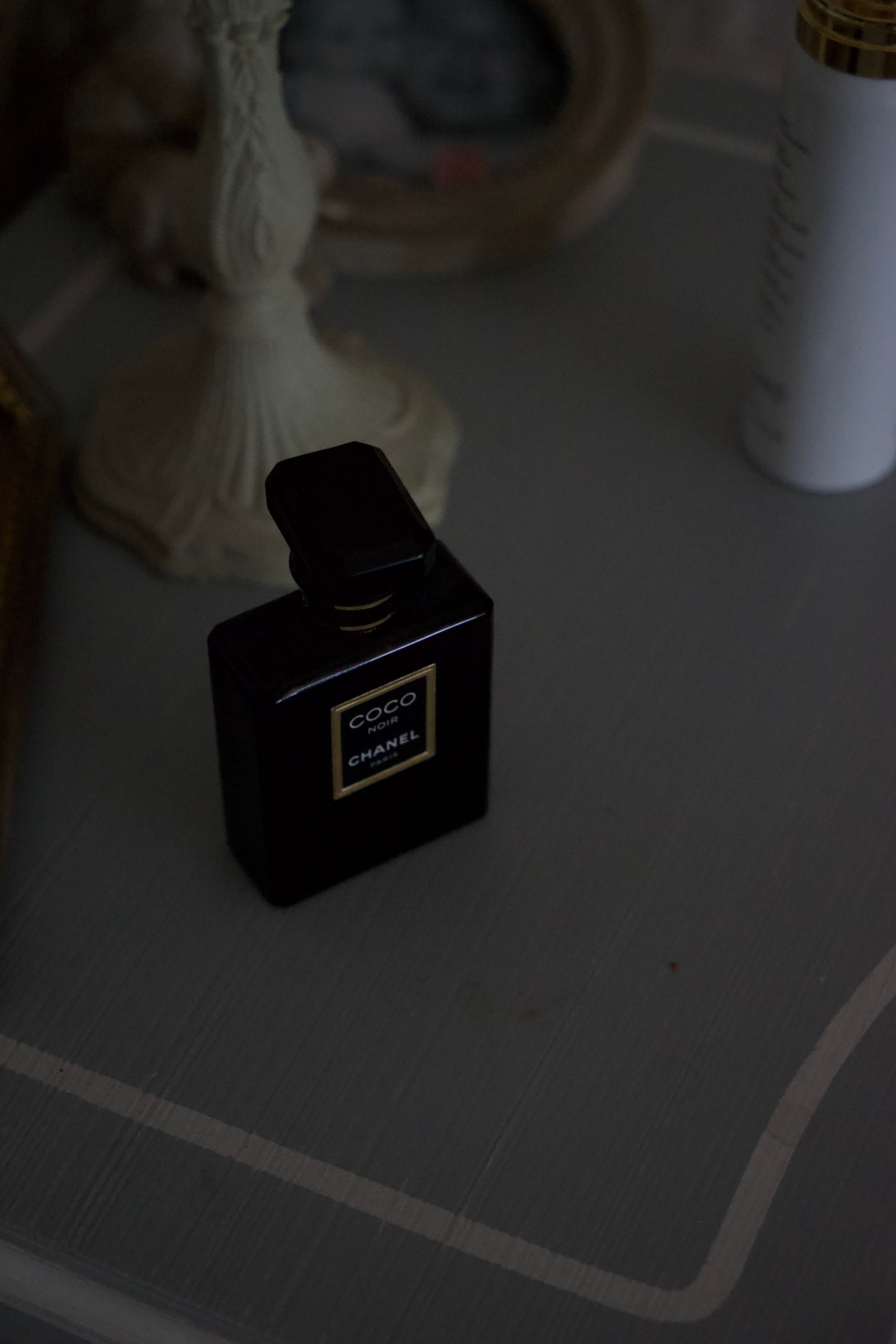 Chanel Perfume Drum Beside Green Sofa and Blue Stool · Free Stock Photo