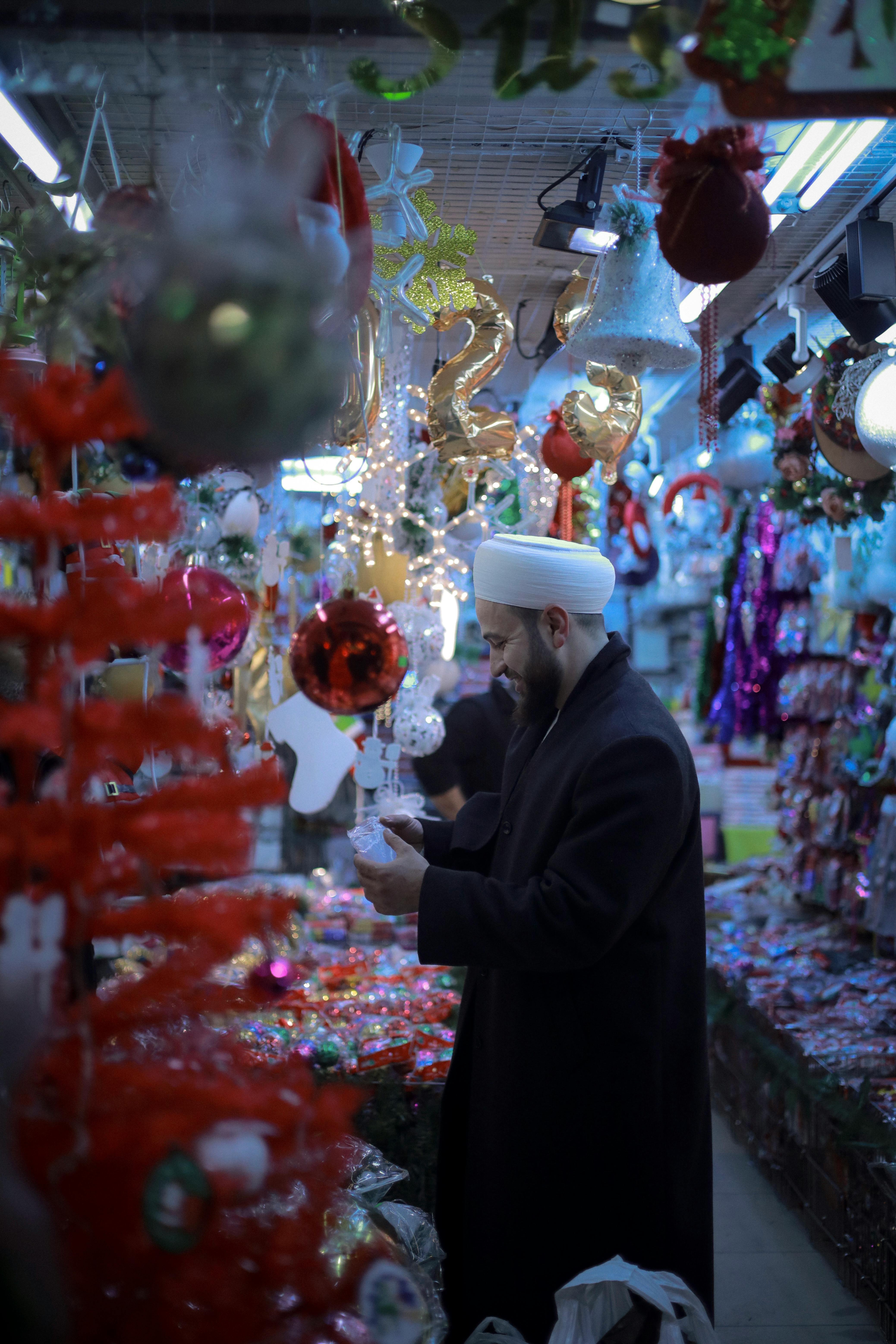 Man Standing in Store with Decorations · Free Stock Photo