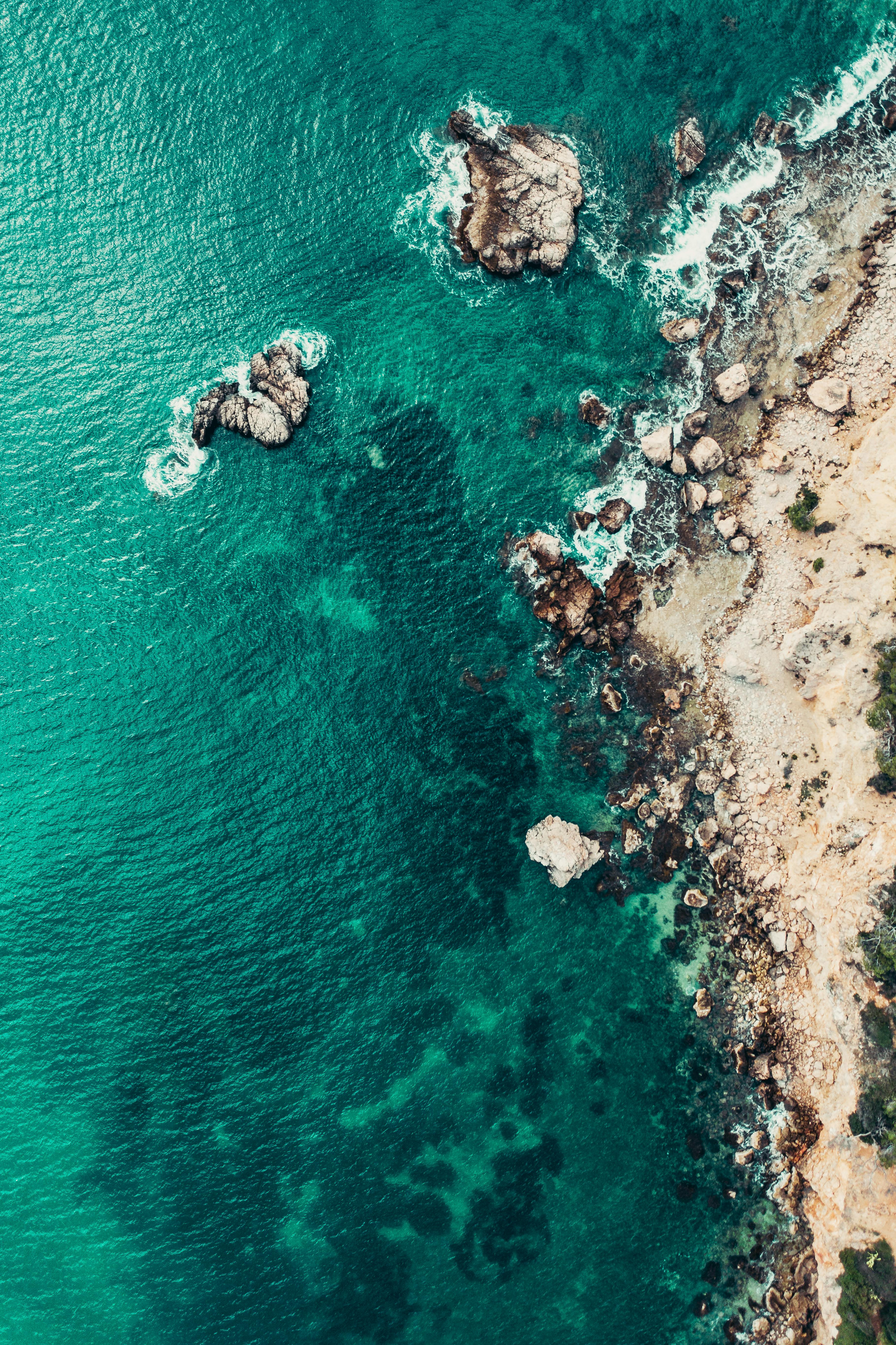 Aerial View of Rocky Coastline of a Turquoise Sea · Free Stock Photo