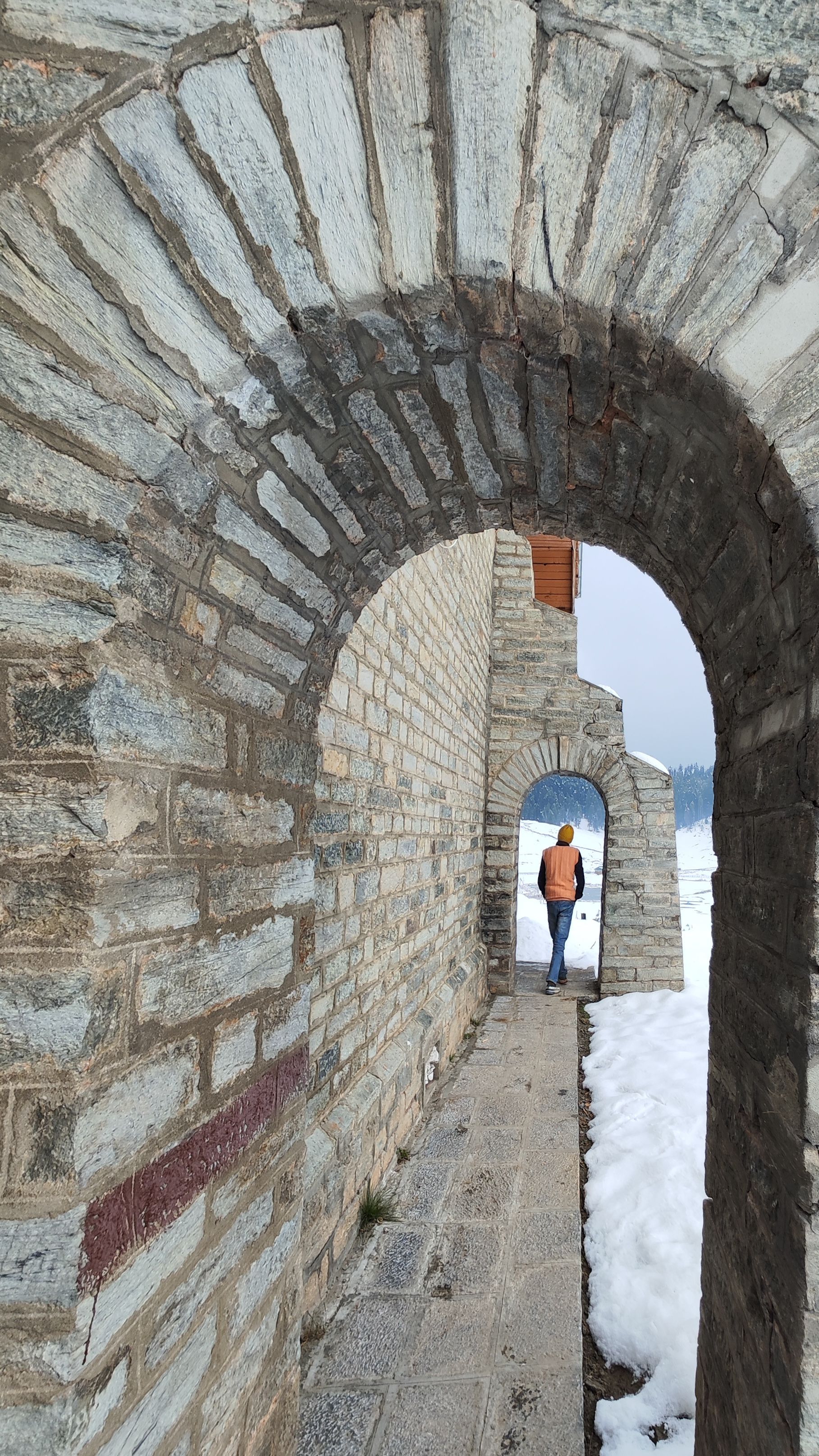 Person Standing under an Arch on the Side of a Fortress · Free Stock Photo