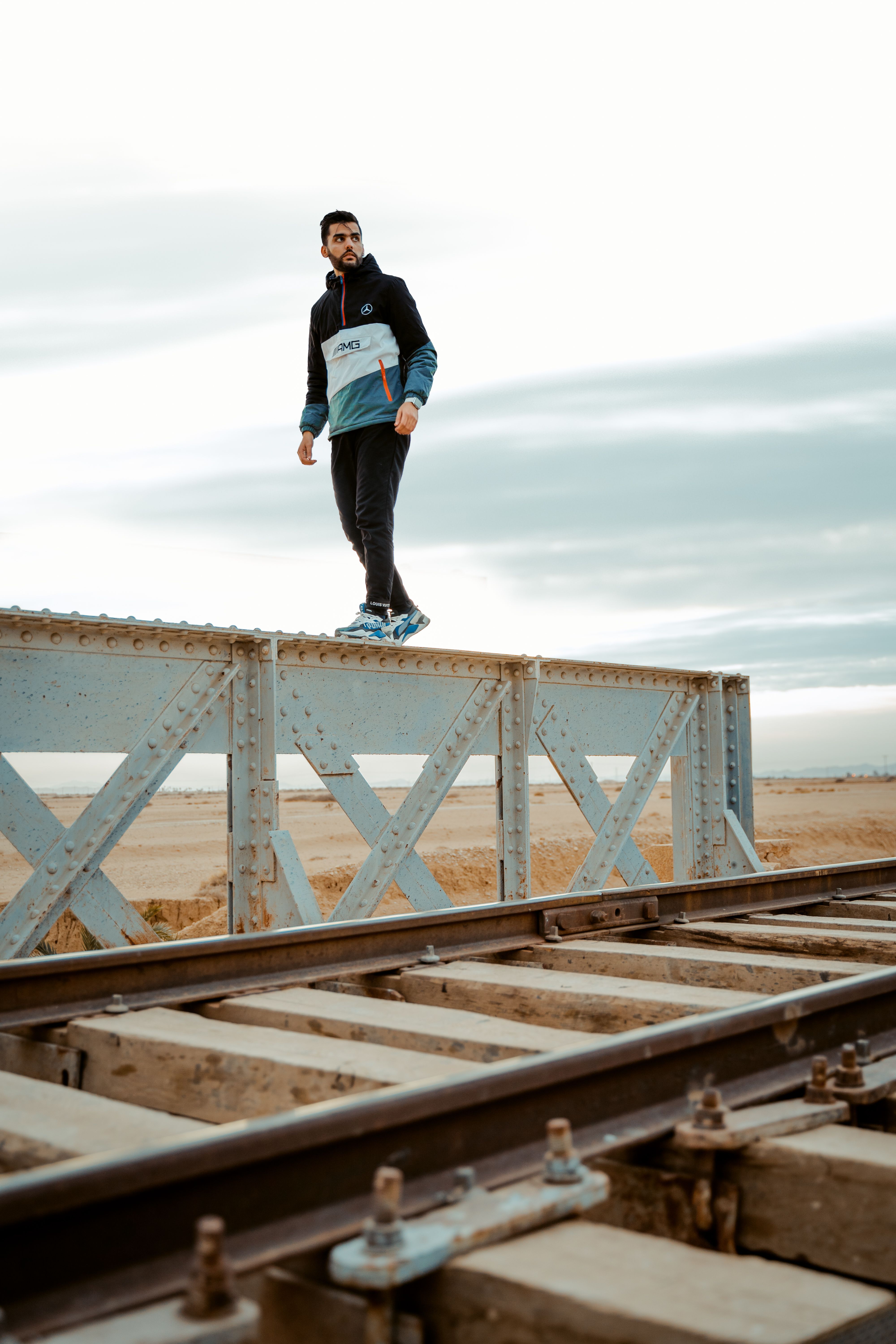 Man Standing on Metal Barrier by Railway Track · Free Stock Photo