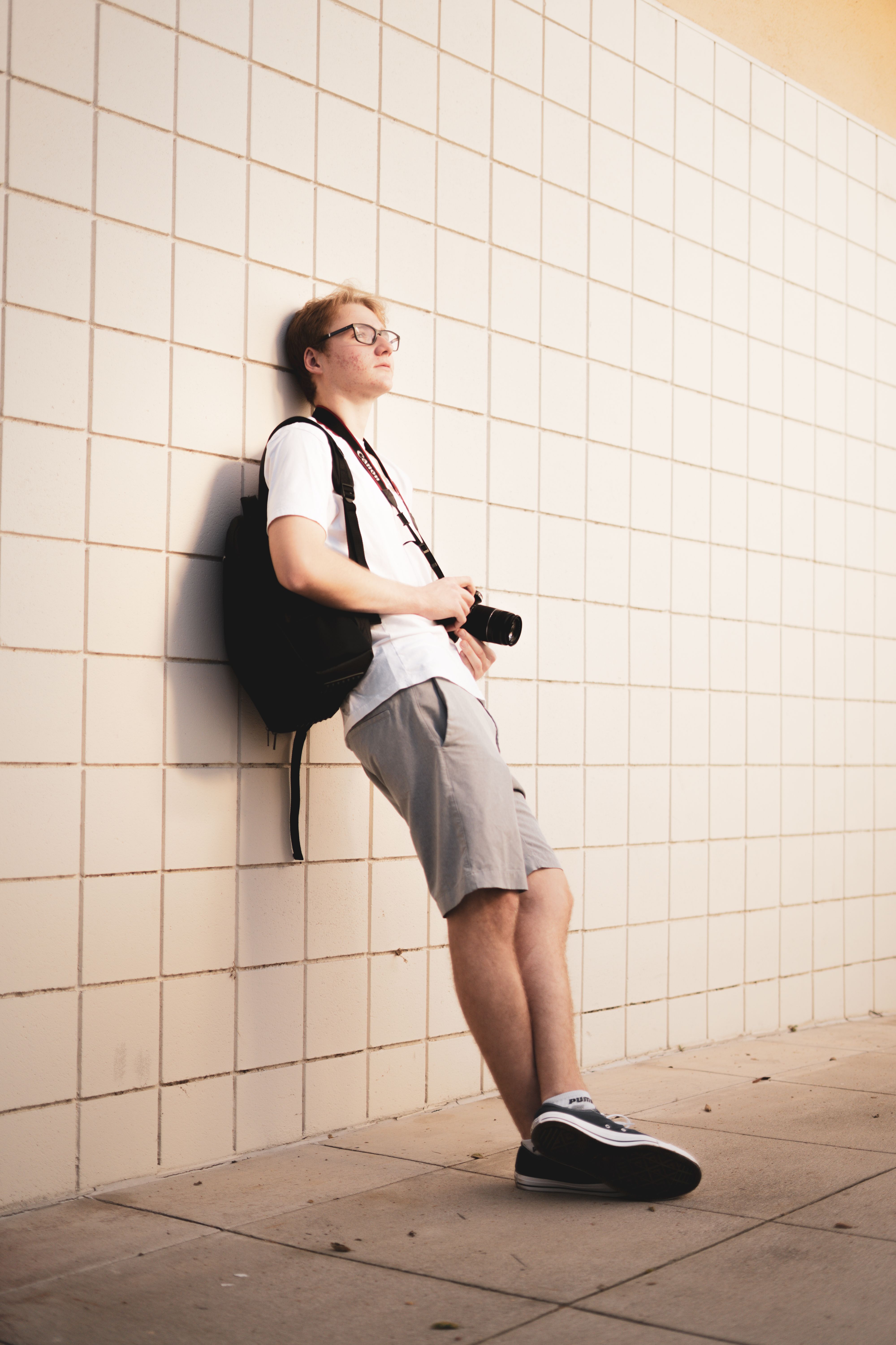 Male Model Wearing a Gray Sweatshirt Standing on One Leg in Front of a ...