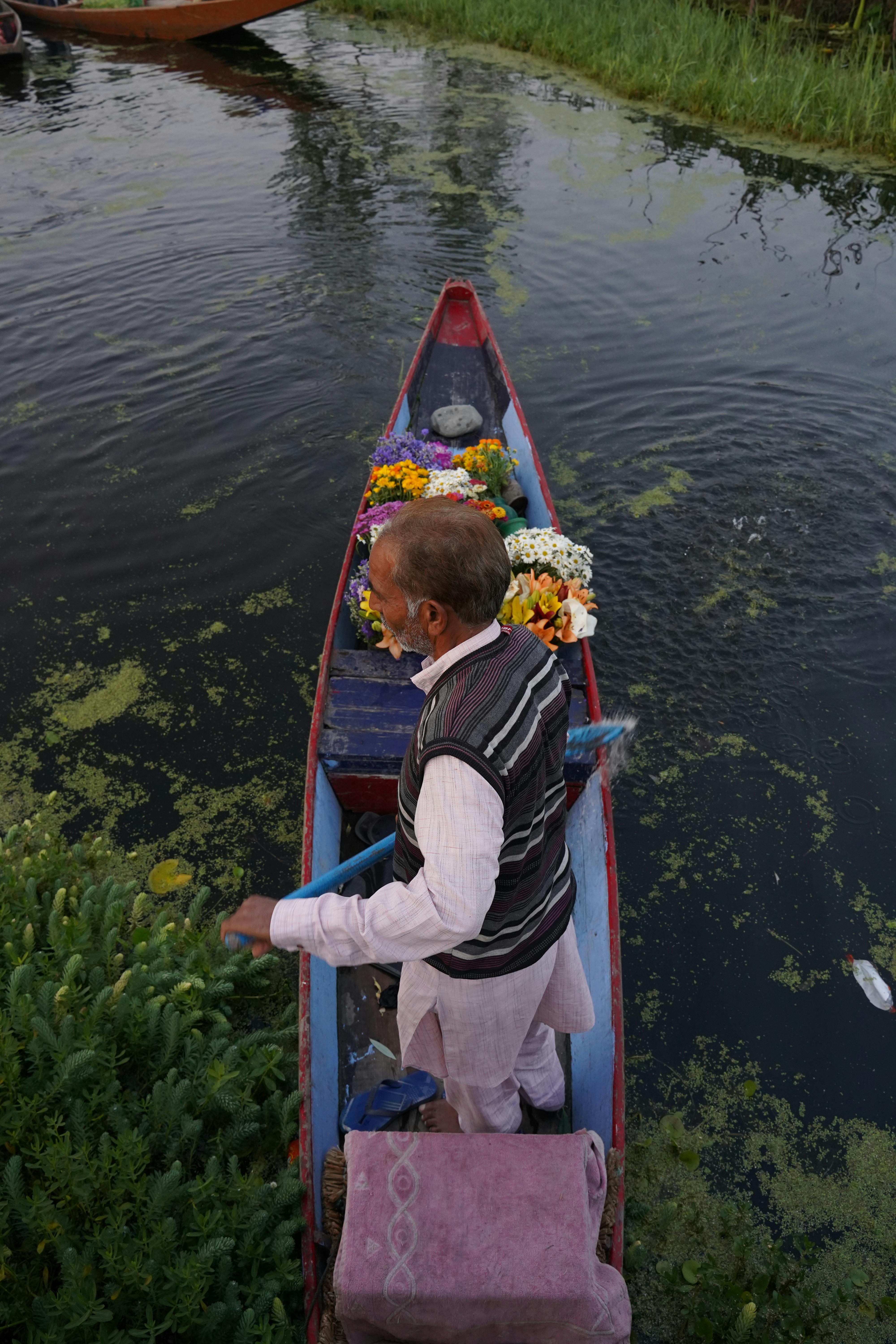 Man on a Gondola with Flower Bouquets · Free Stock Photo