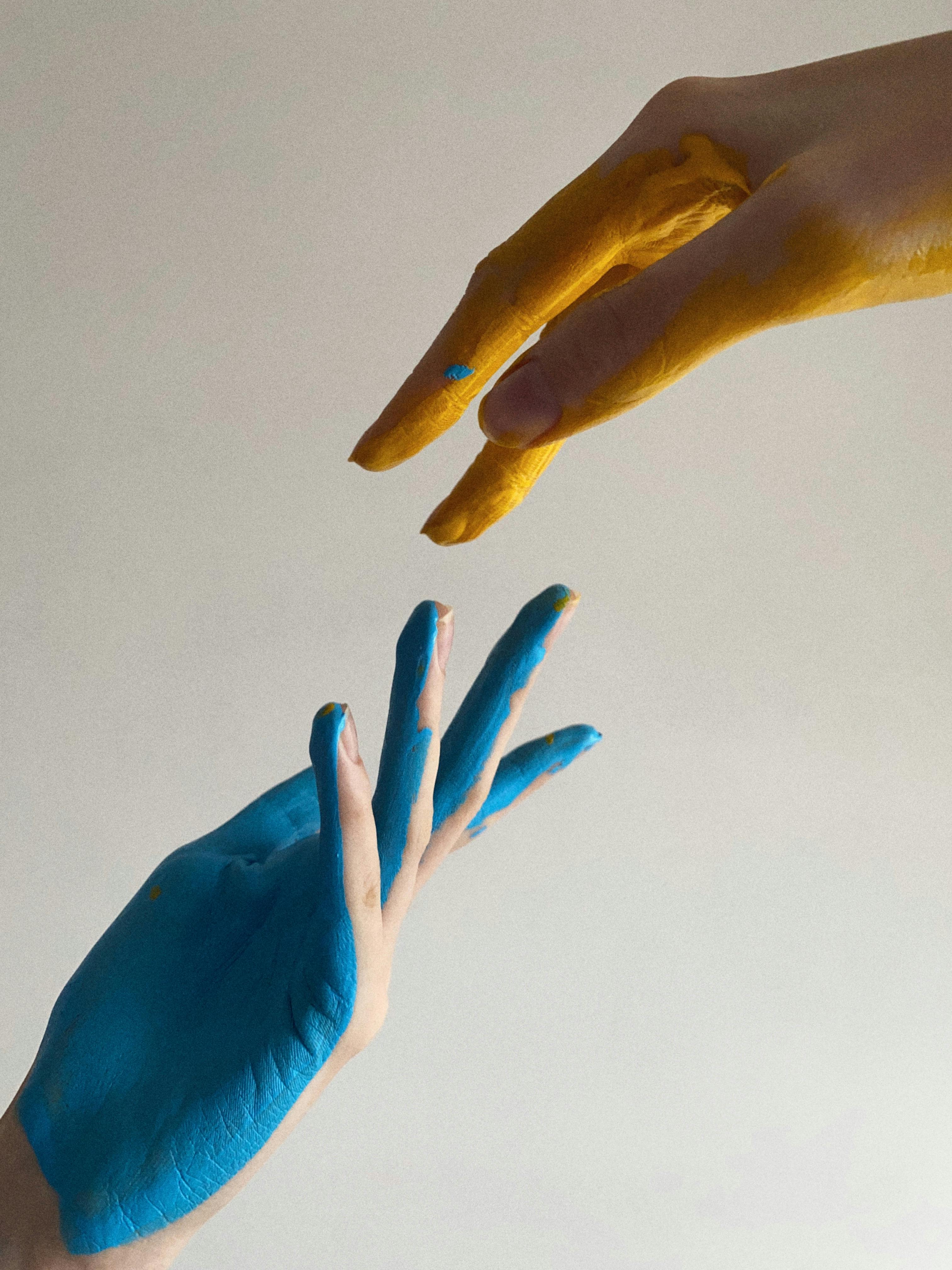 Two Hands with Paint Reaching Out Towards Each Other · Free Stock Photo