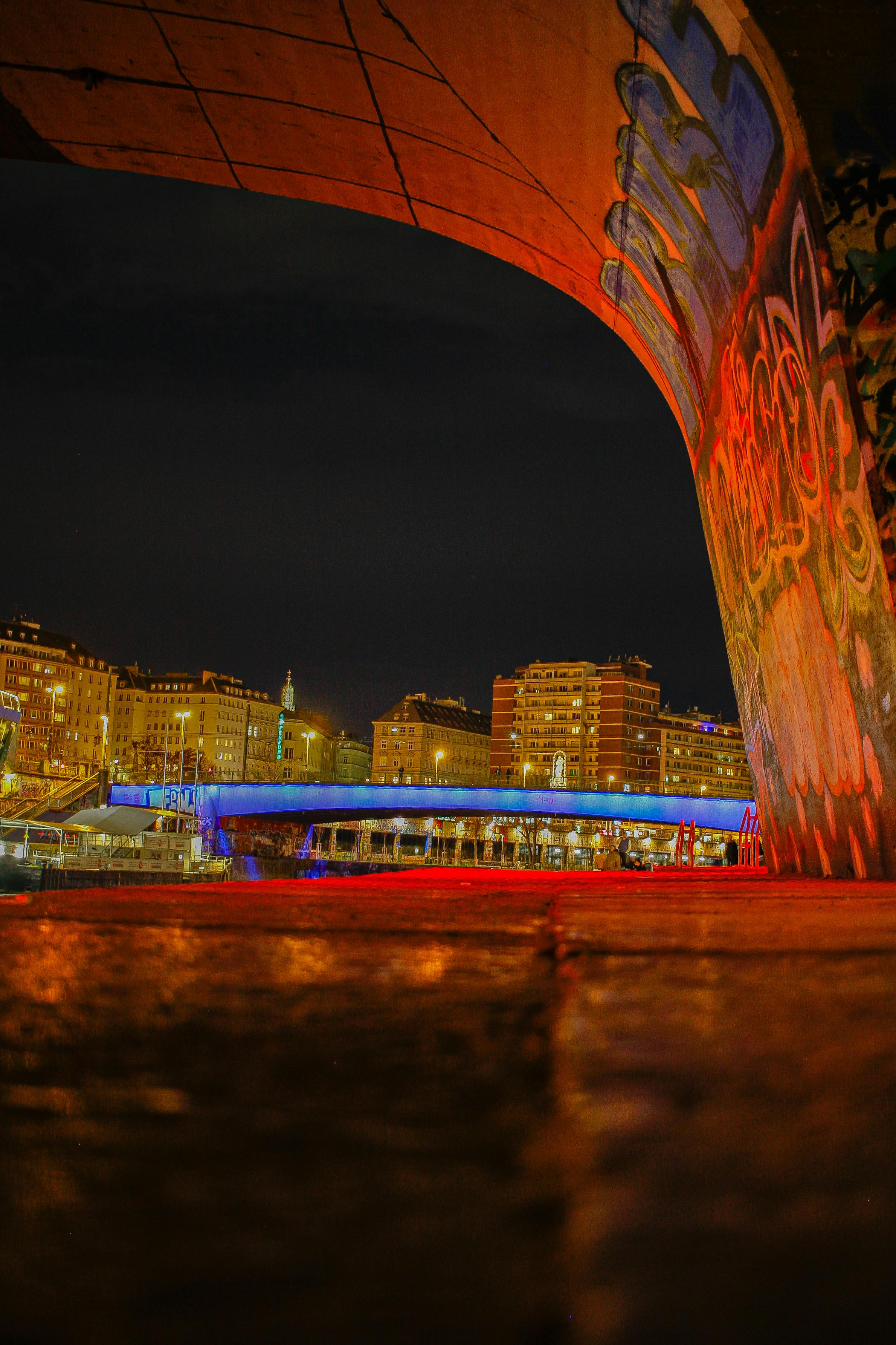Illuminated City Buildings and Bridge behind Wall at Night · Free Stock ...