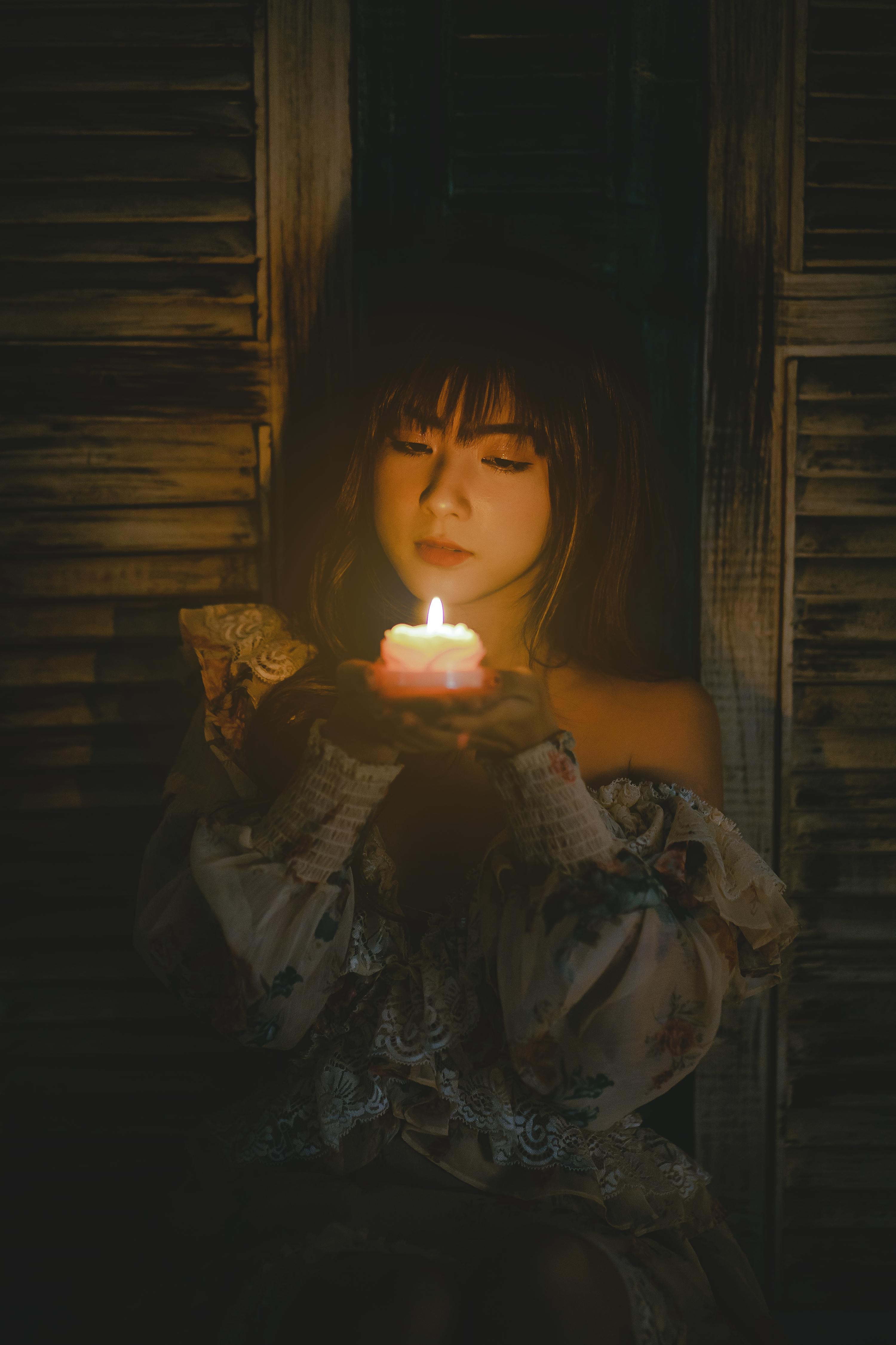 Woman Holding a Lit Candle in the Dark · Free Stock Photo