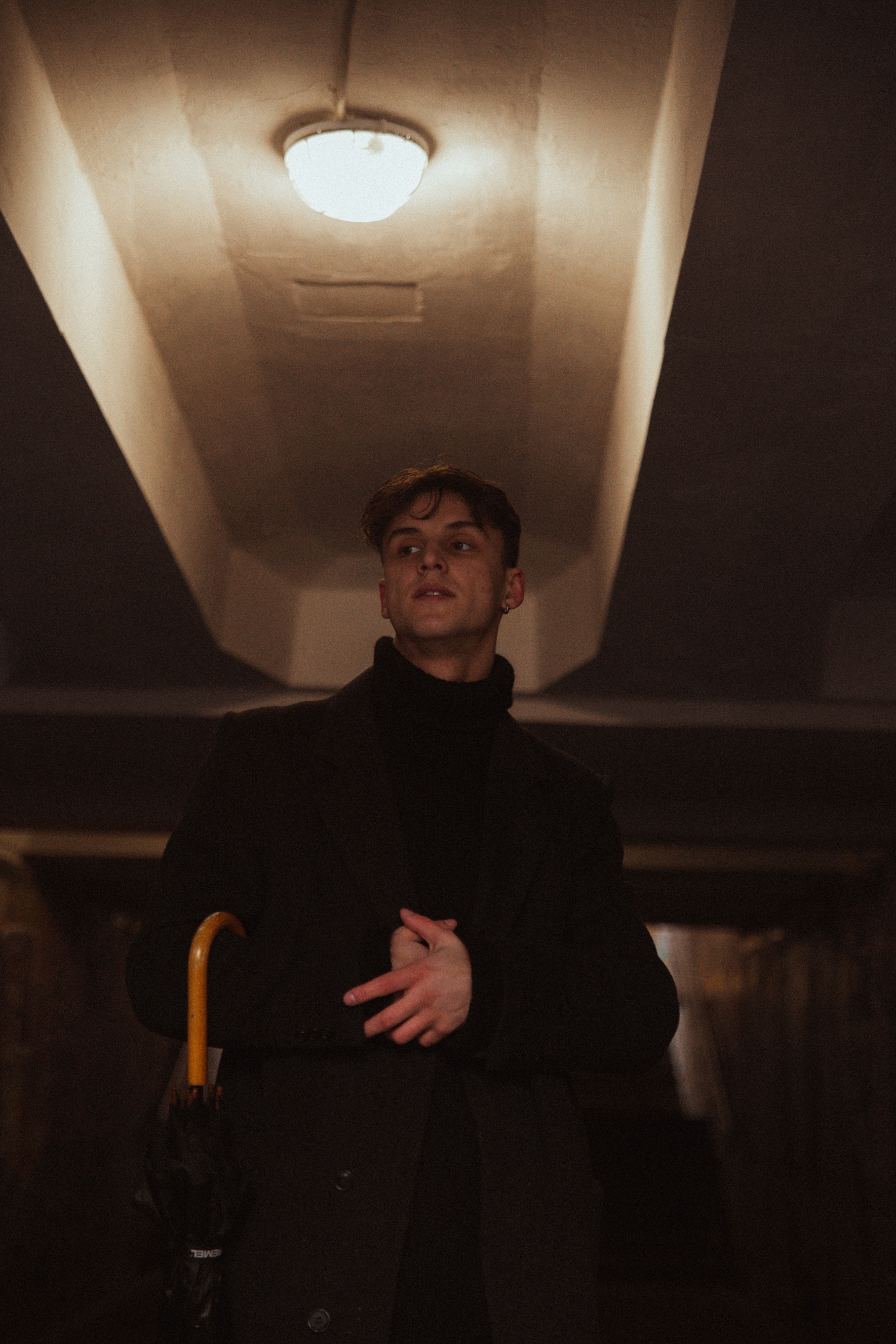 Low Angle Shot of Man in Black Coat With Umbrella · Free Stock Photo