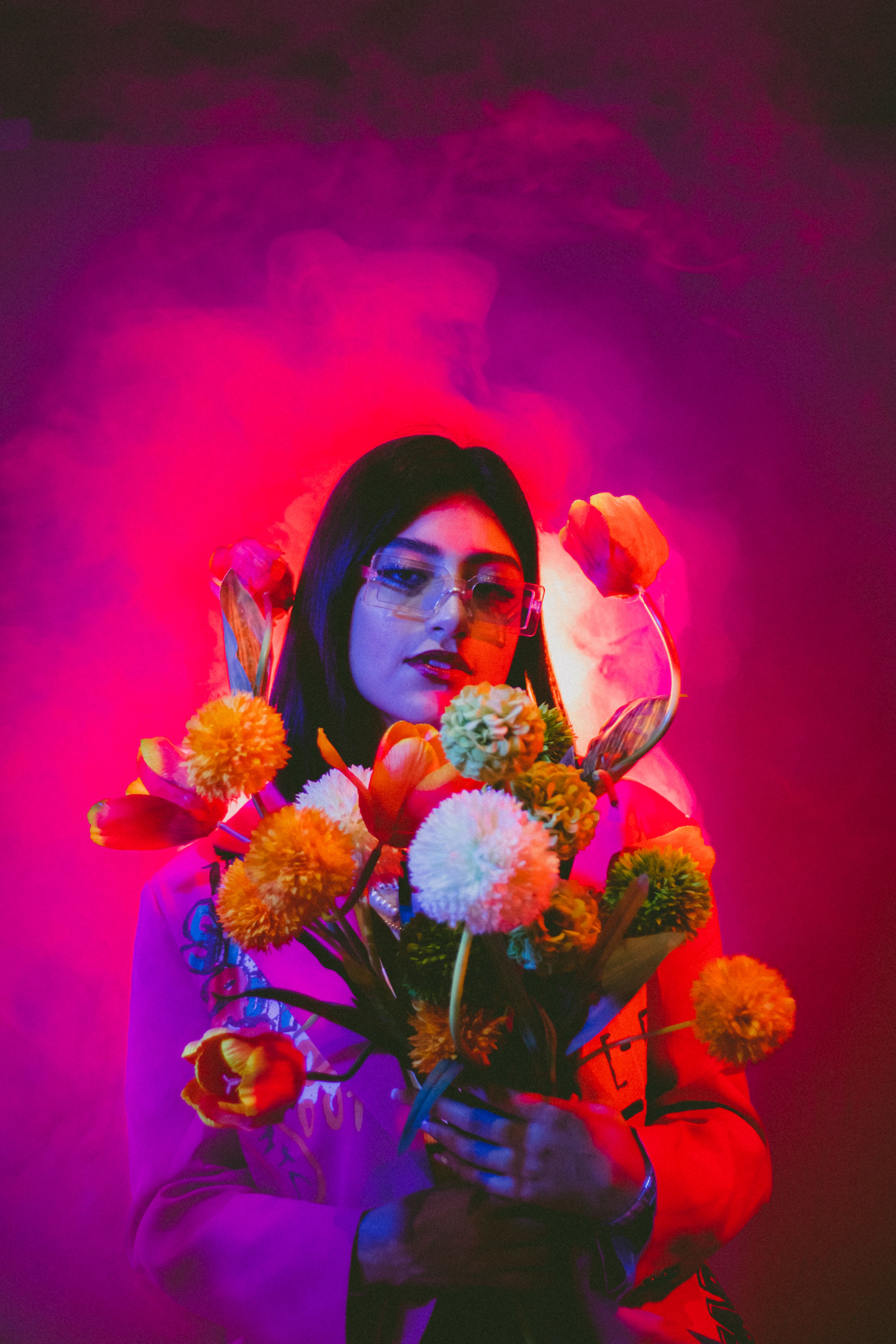 Woman Posing with Flowers on Colorful Background · Free Stock Photo