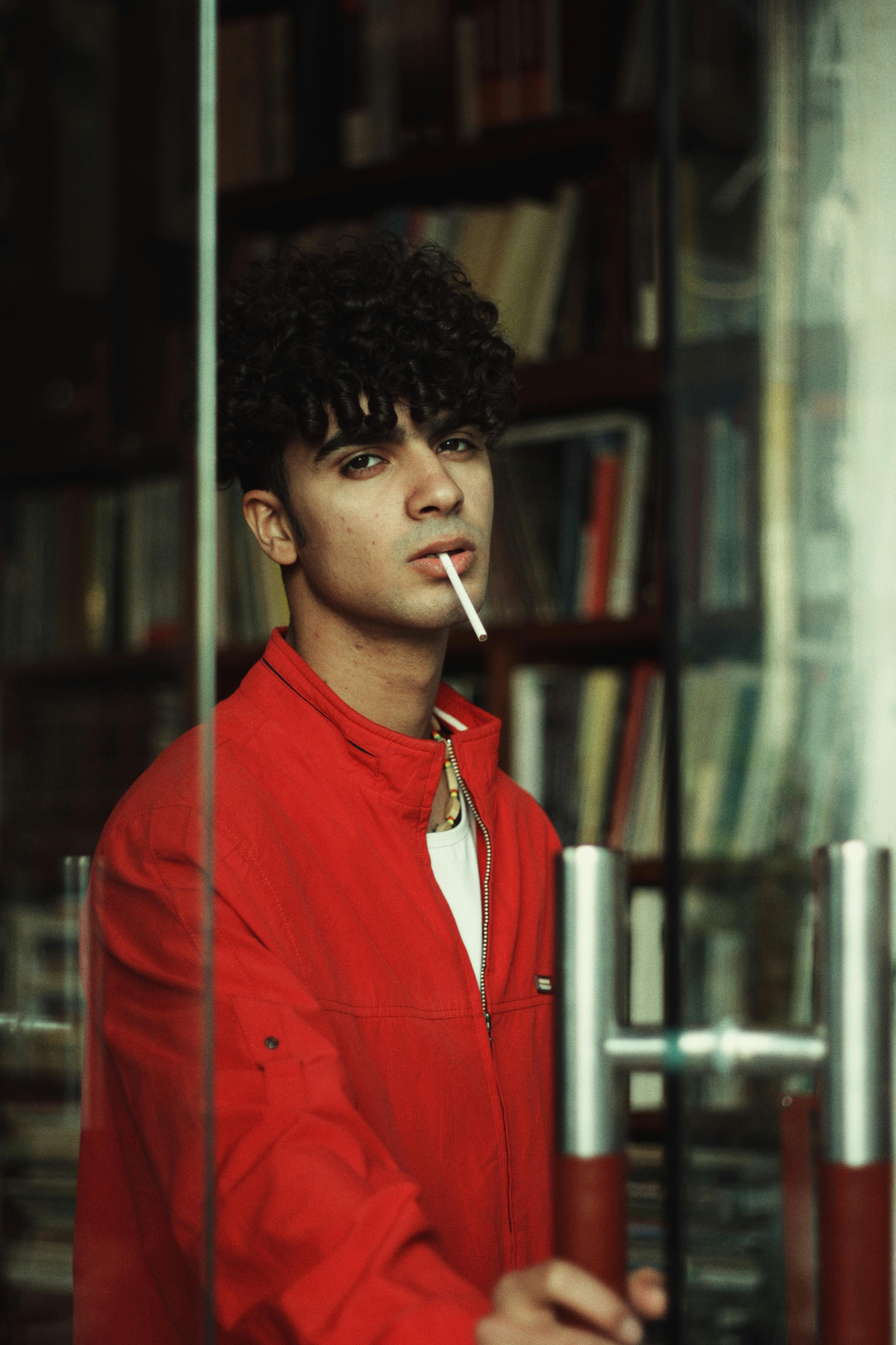 A Curly Haired Man with Cigarette in Mouth Wearing Red Jacket · Free ...