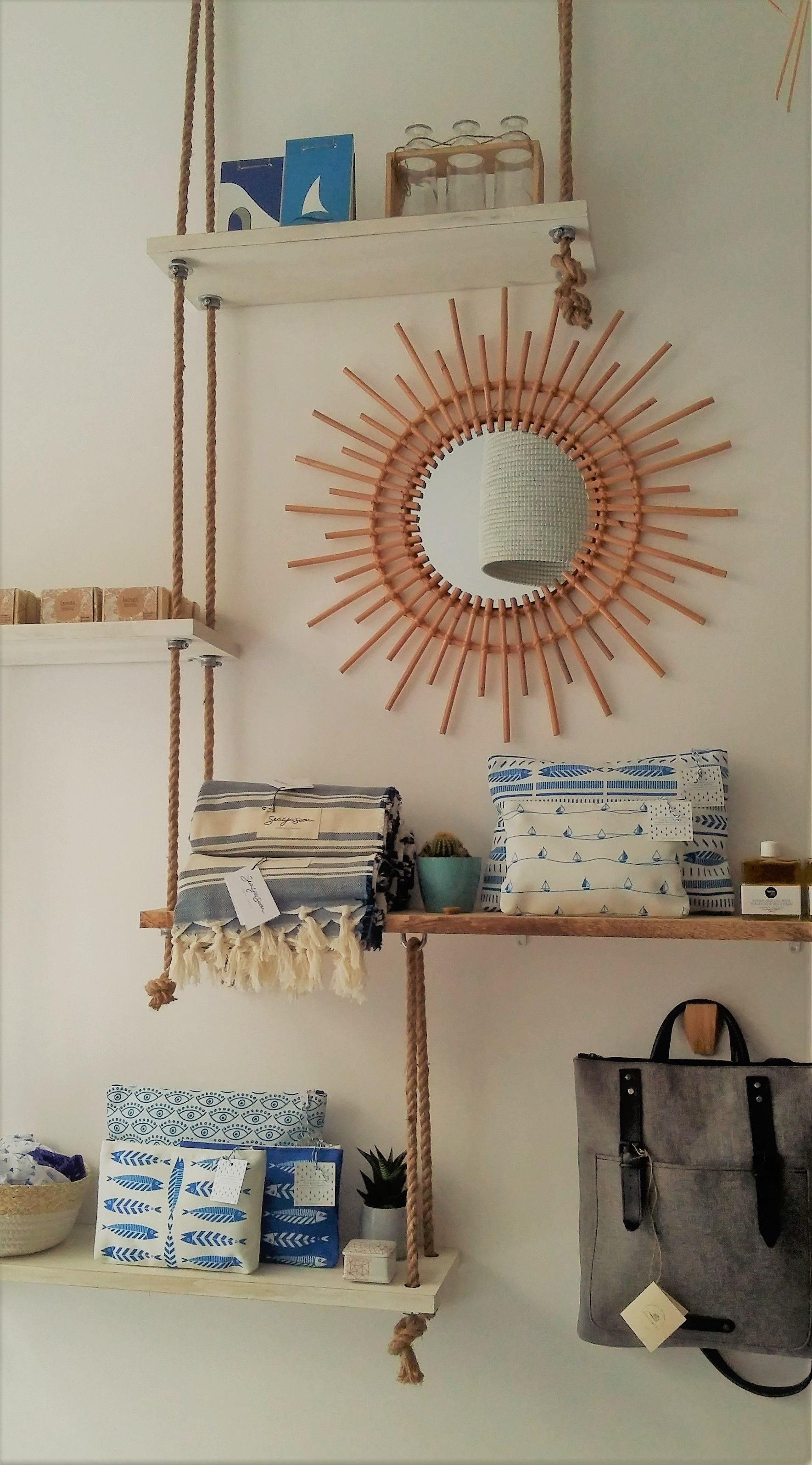 A Set of Hanging Wooden Shelves with a Sun Designed Mirror on a White ...