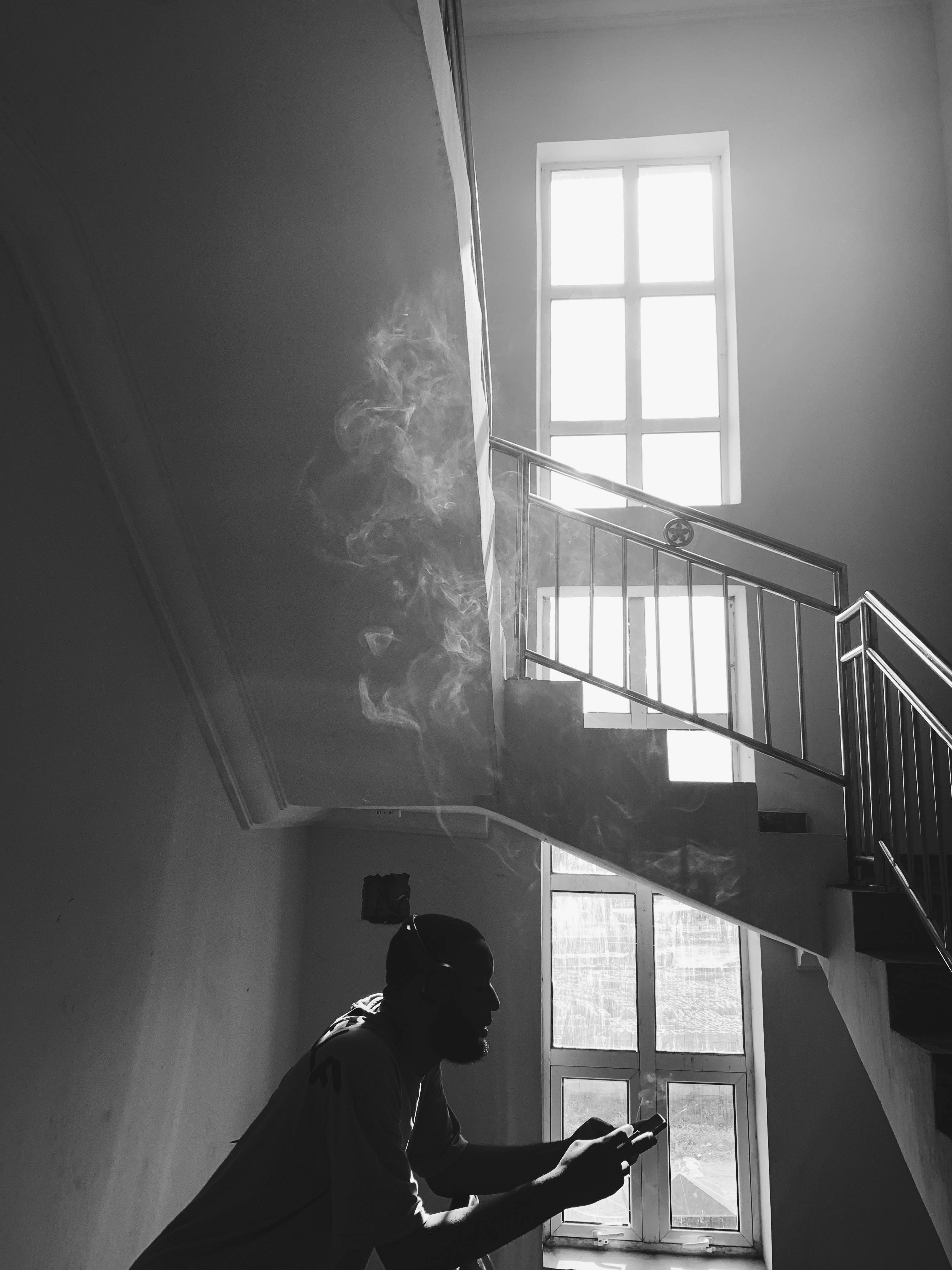 Silhouette of a Man Smoking while Leaning on a Metal Railing · Free ...