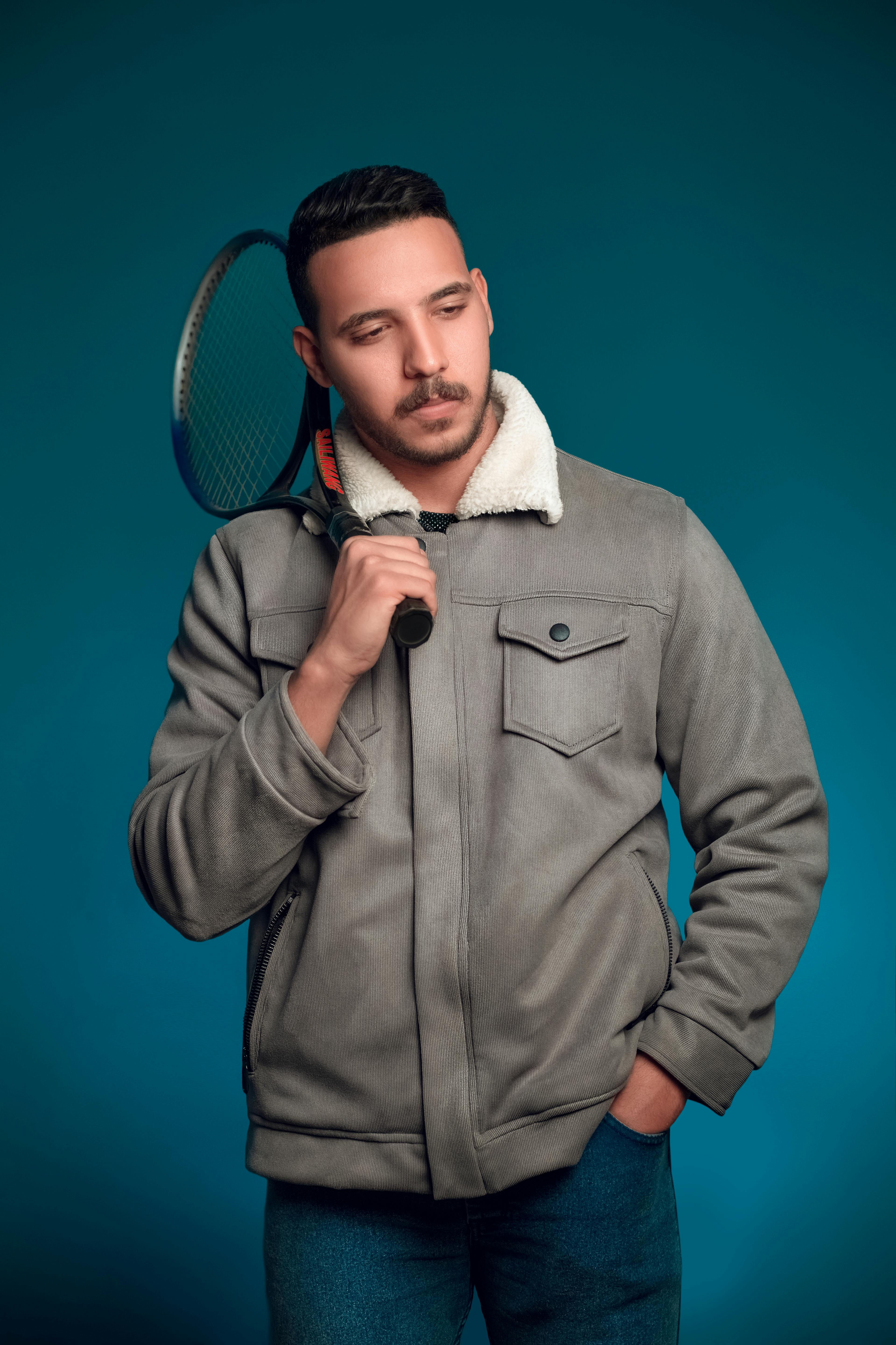 A Man Wearing a Grey Jacket Holding Tennis Racket · Free Stock Photo