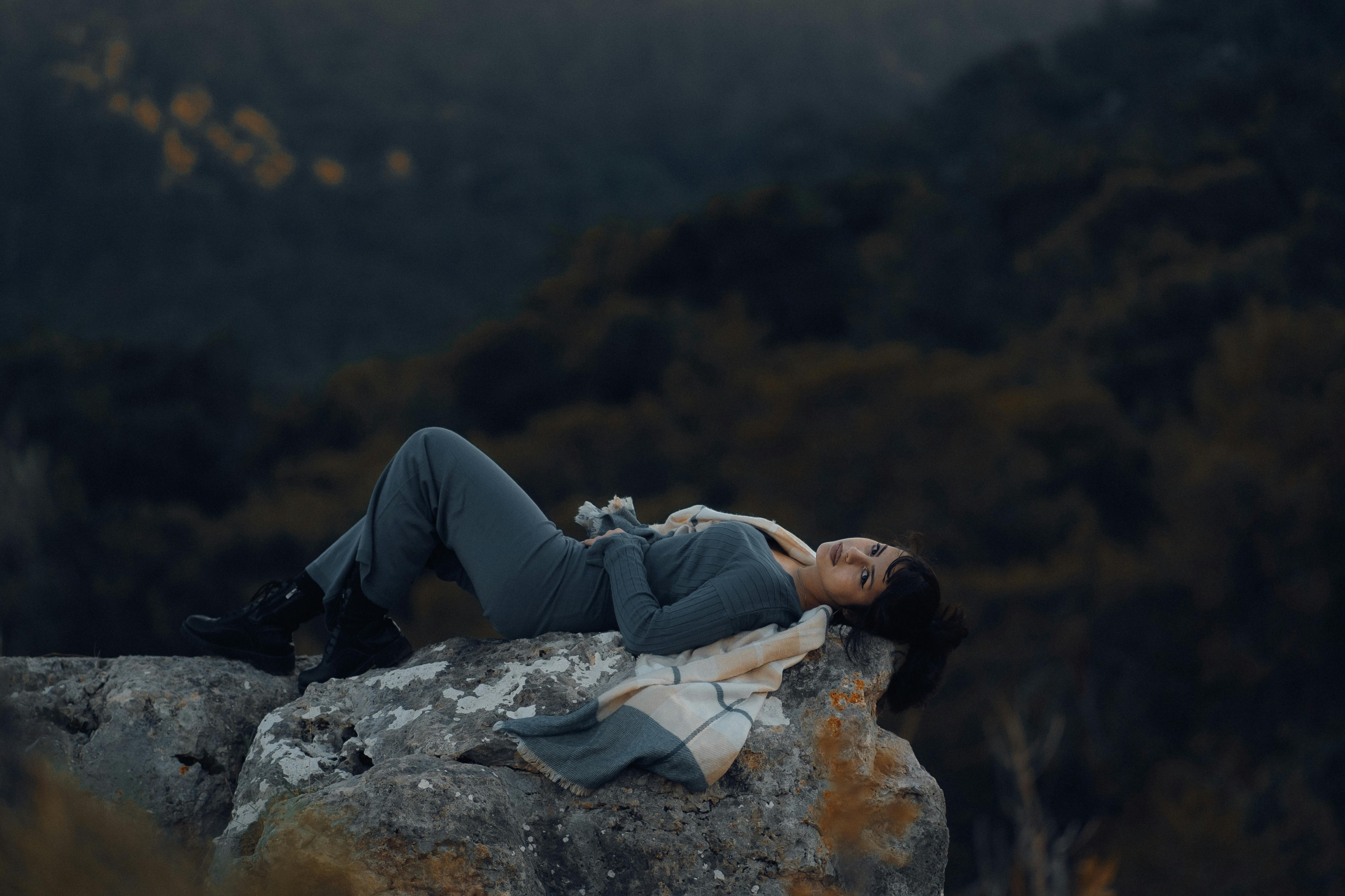 Woman Lying on Mountain Cliff · Free Stock Photo