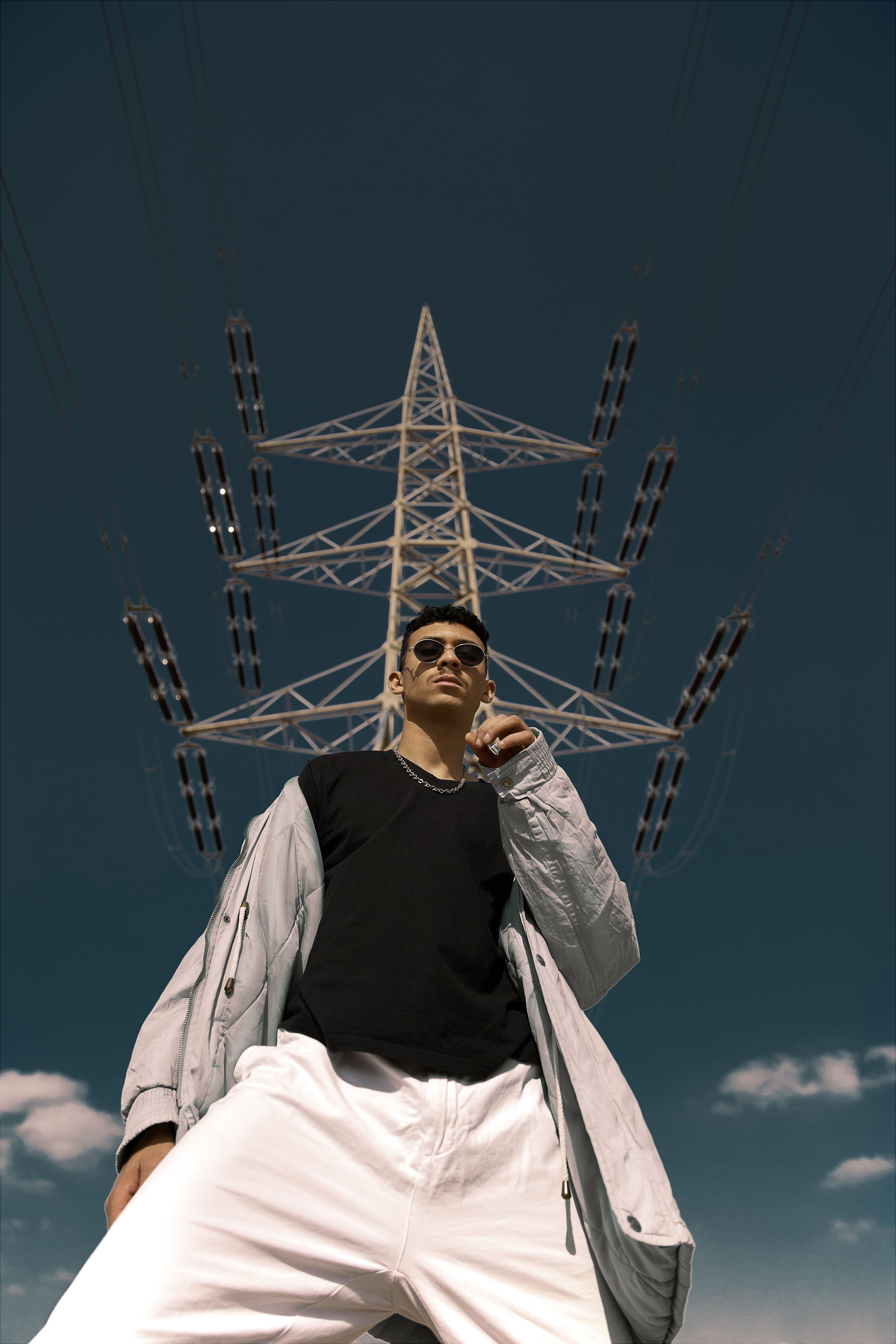 Man Standing beside Electrical Post under Gray Sky · Free Stock Photo